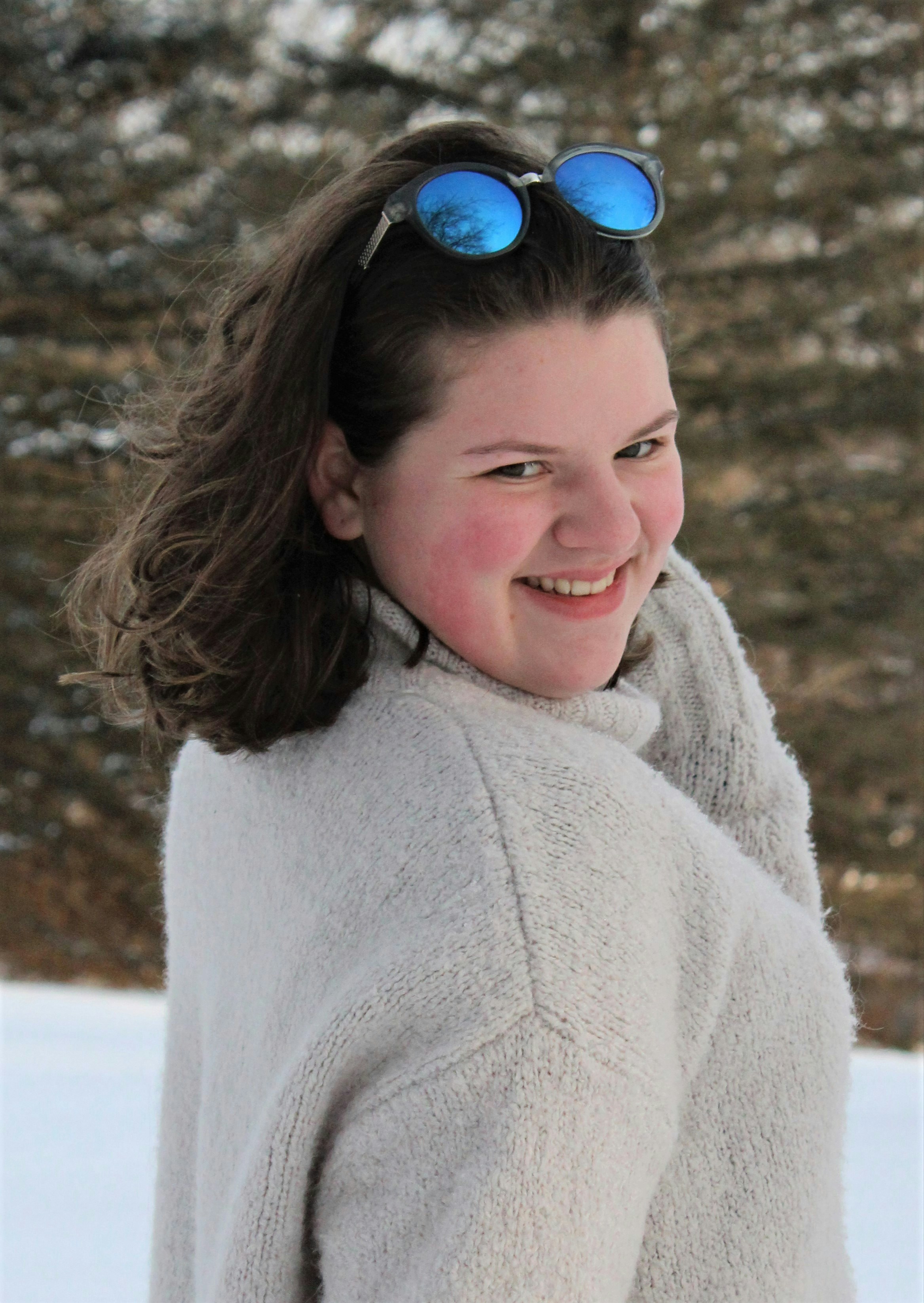 Snow-Kissed Portrait: Warm Smile Under Blue Reflections