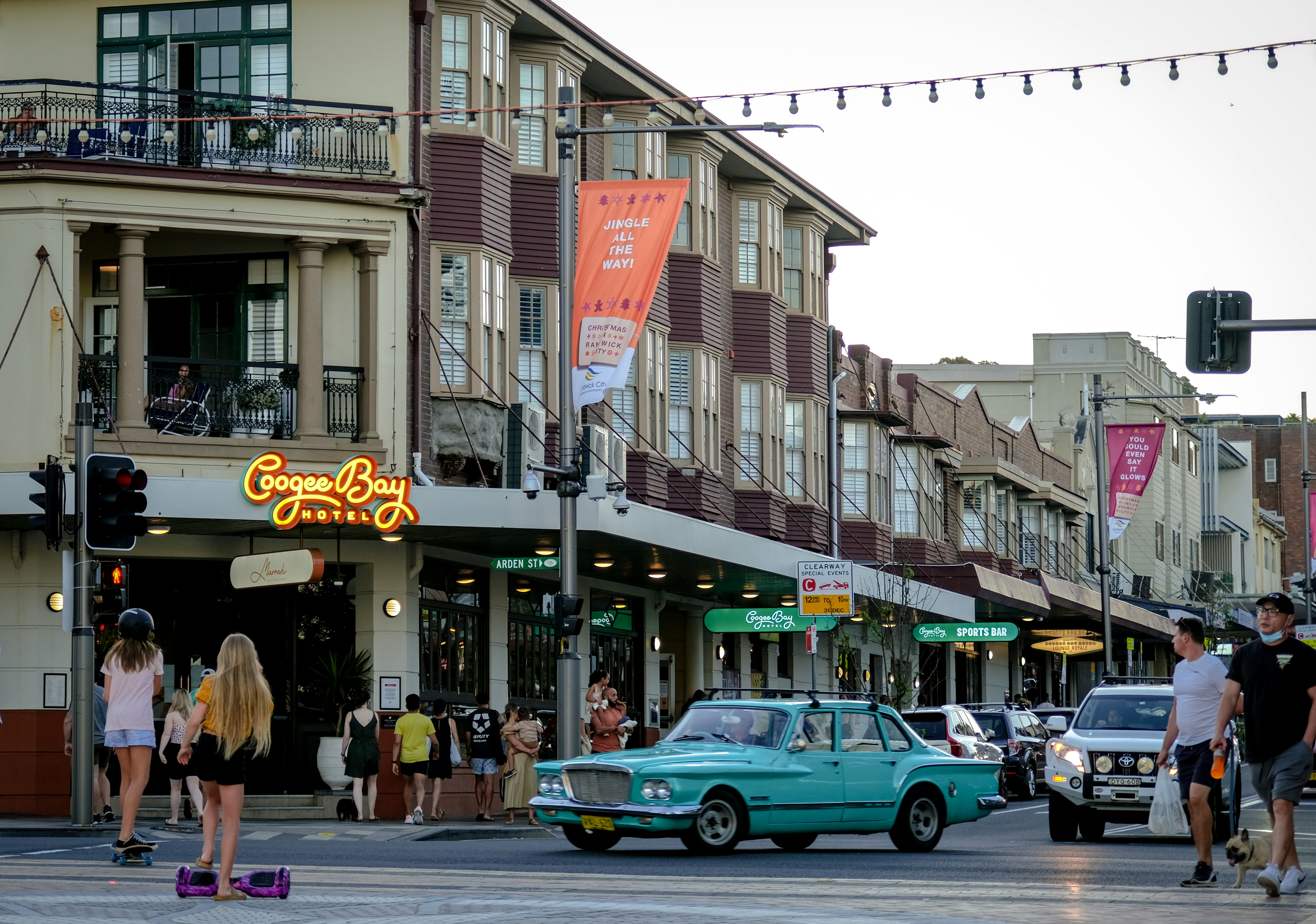 A group of people crossing a street in front of a building photo – Free ...