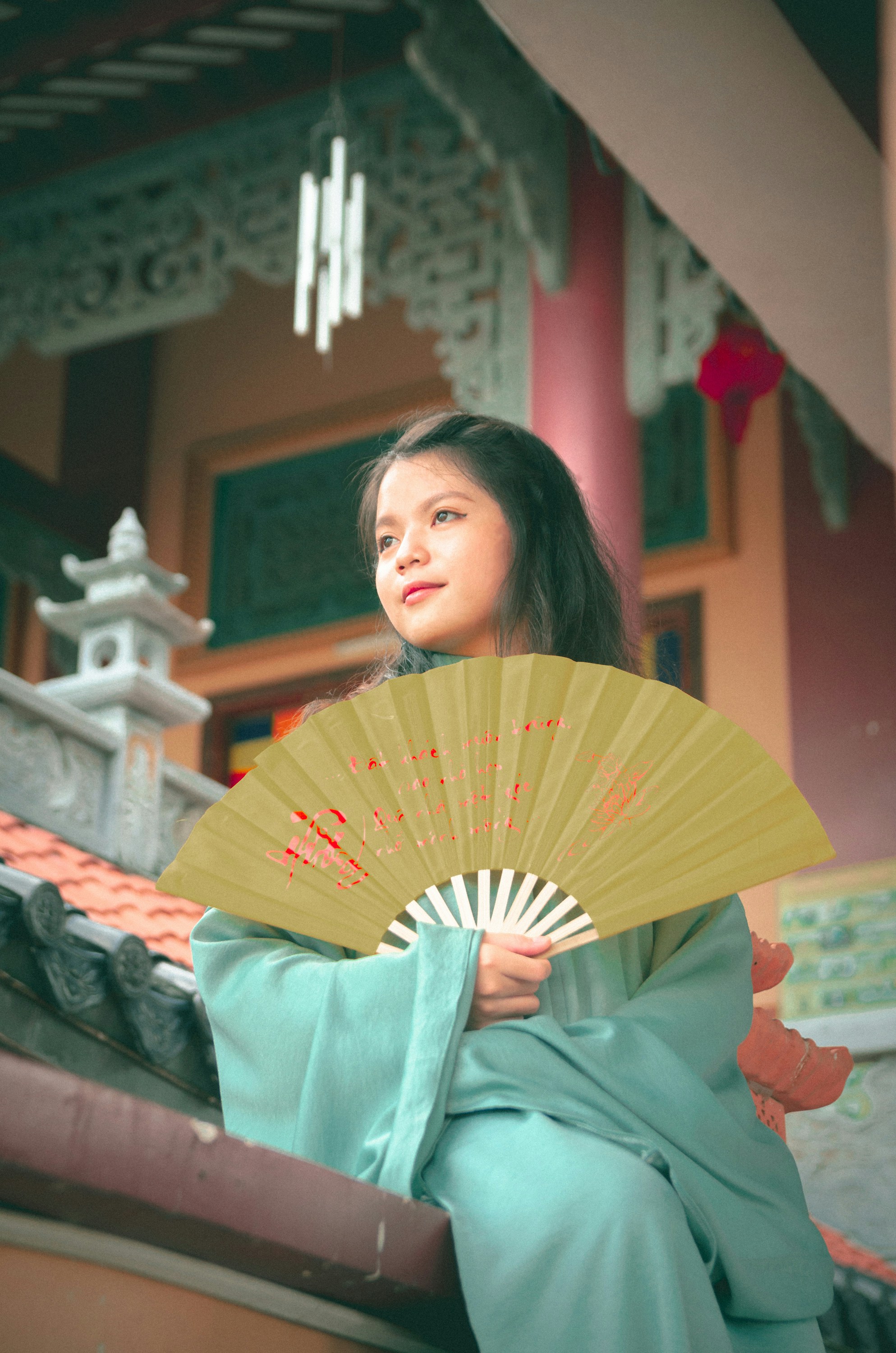 A woman sitting on a ledge holding a fan photo – Free Vietnam Image on ...