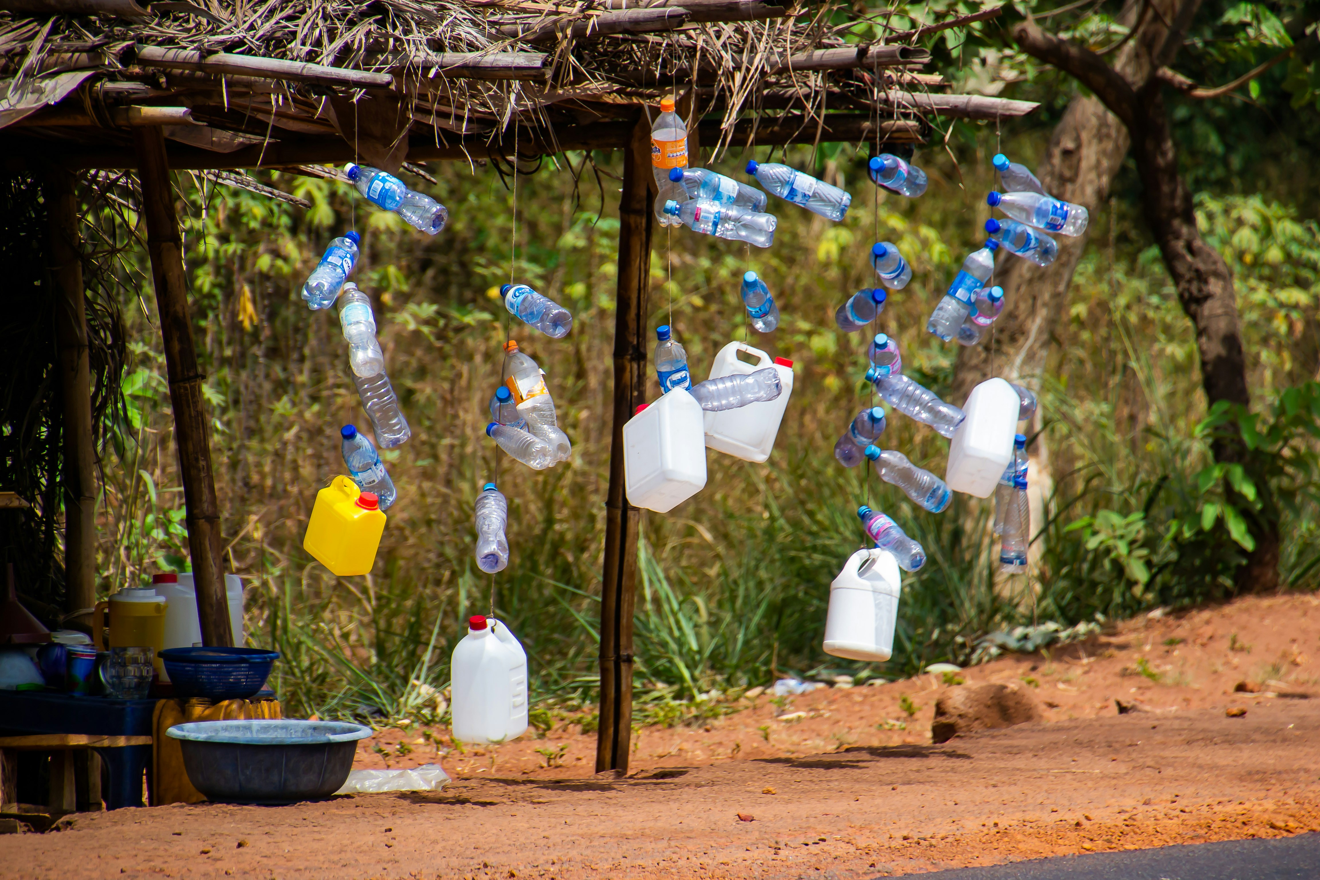 A bunch of plastic bottles hanging from a wooden pole photo – Free ...