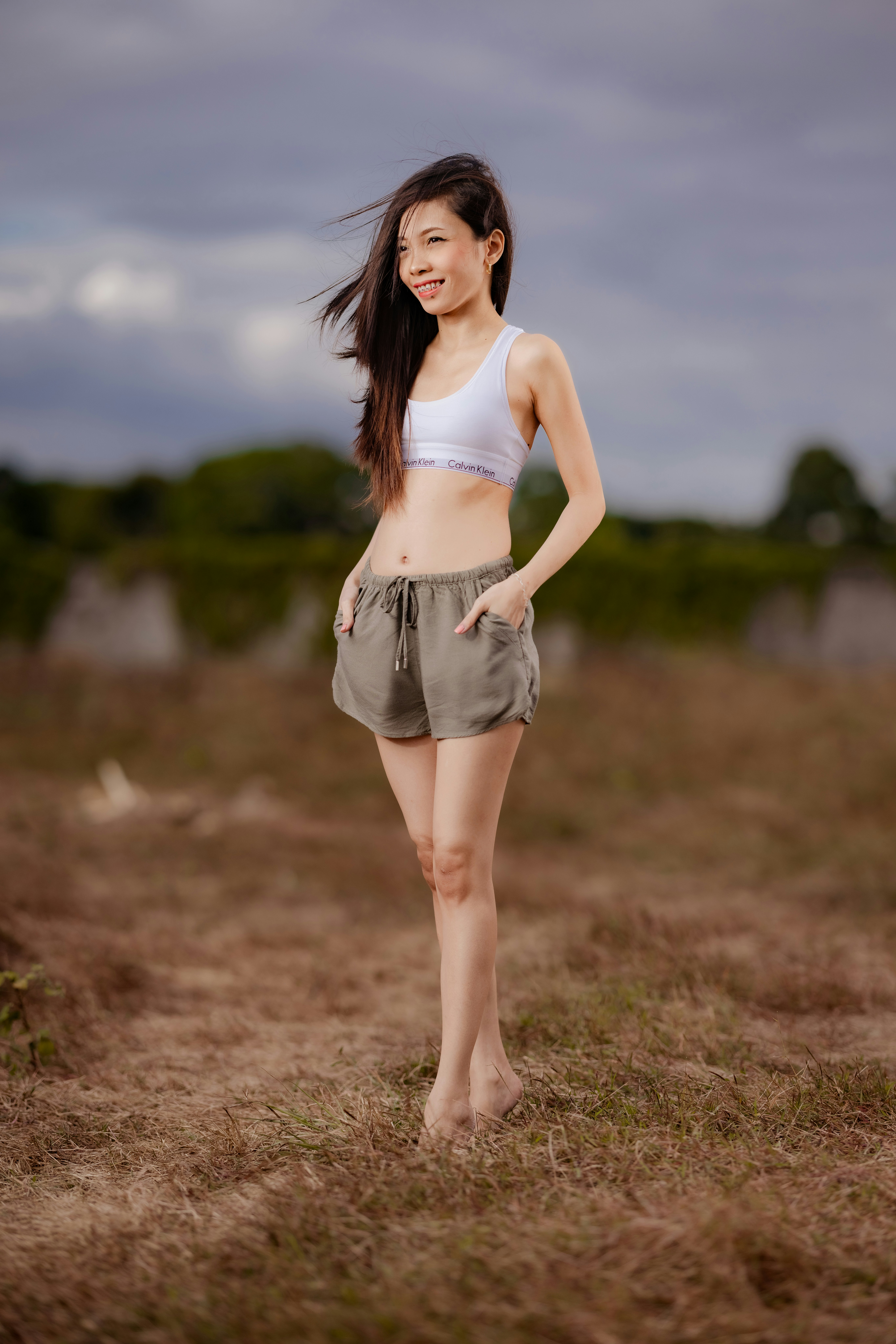 a woman standing in a field with her hands on her hips