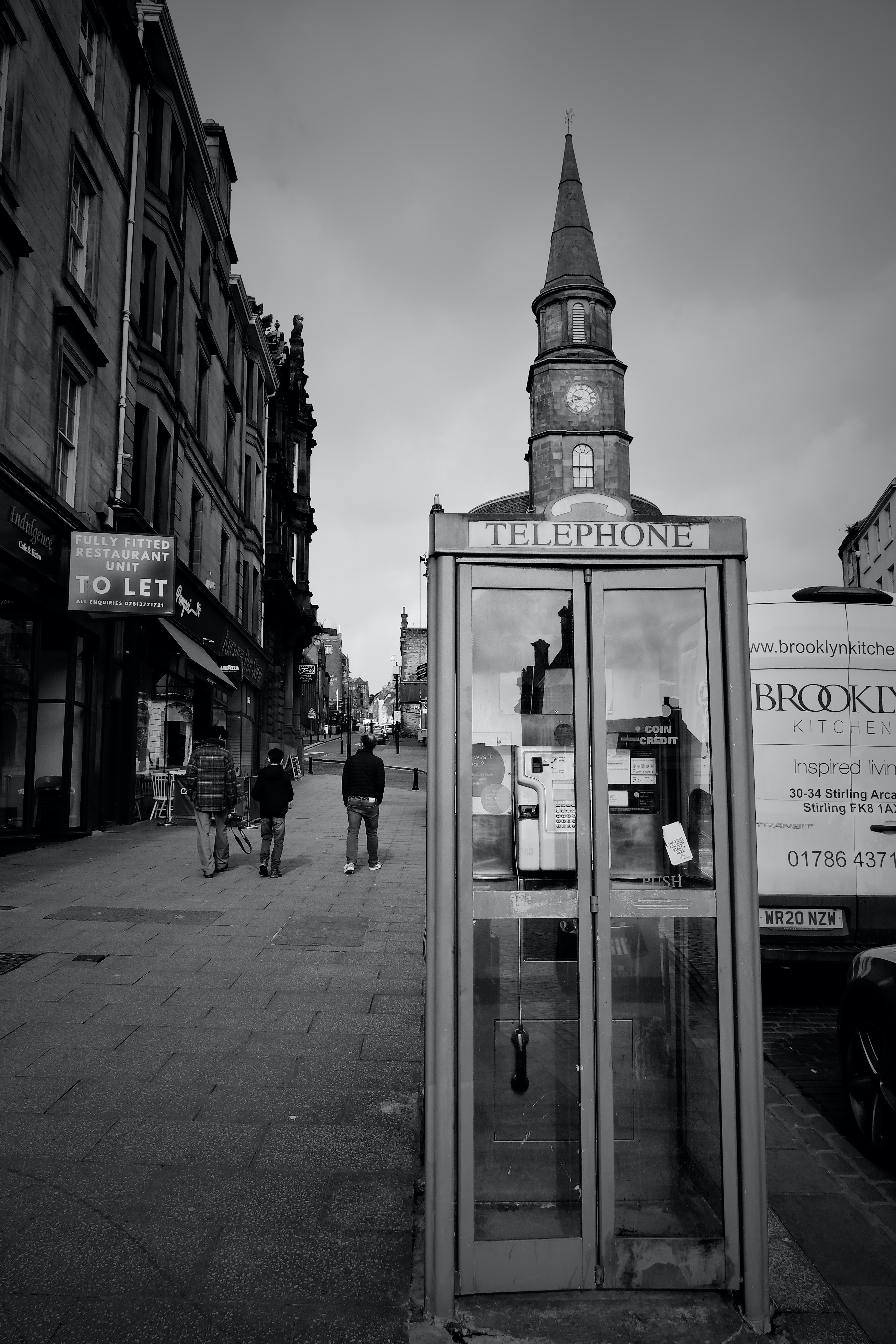 Standstill on a Sloped London Street: The Lone Telephone Booth Framing a Spire