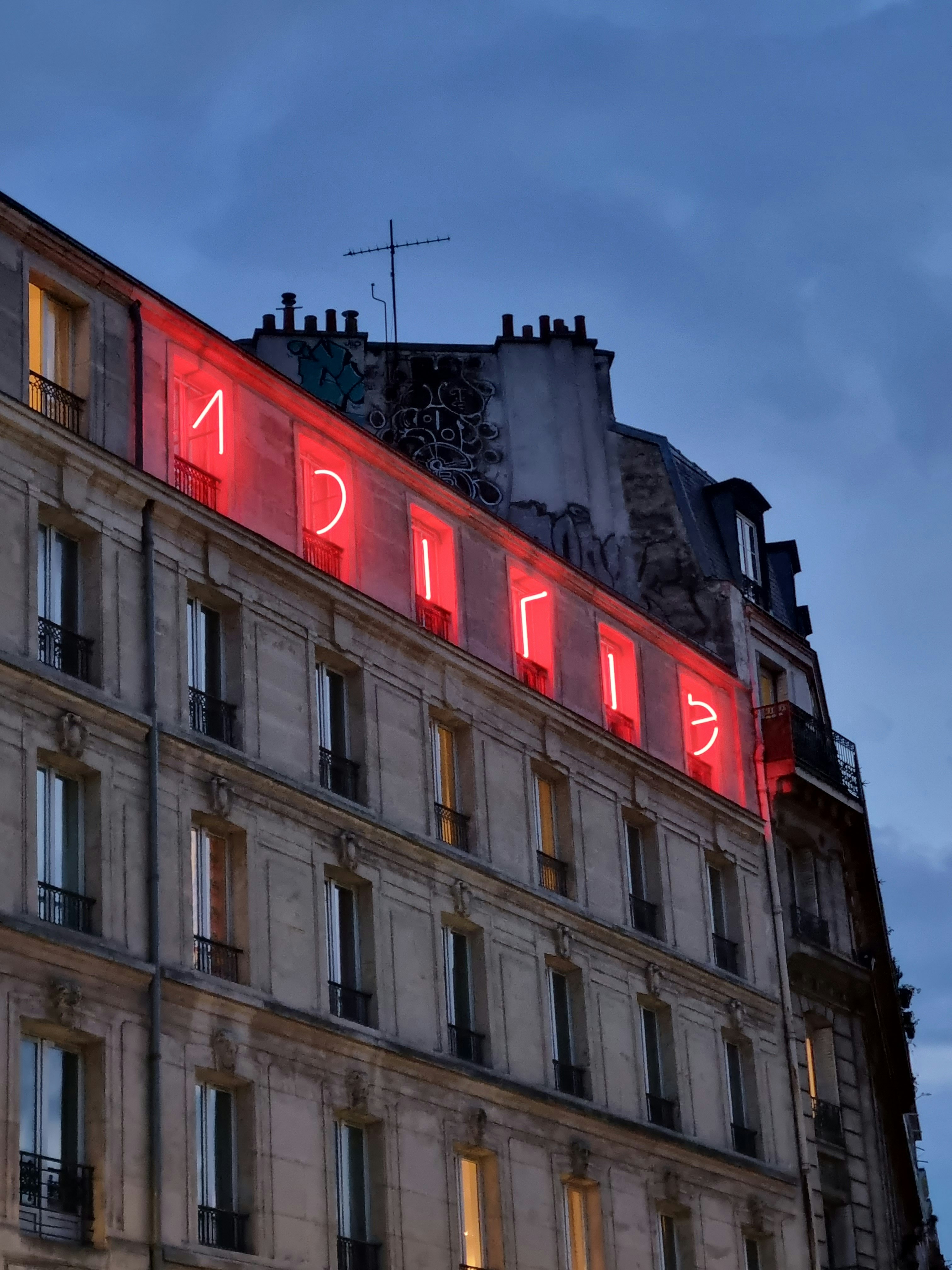 Rooftop Neon: Red Sign Casting a Blue Hour Glow on Haussmann Facade