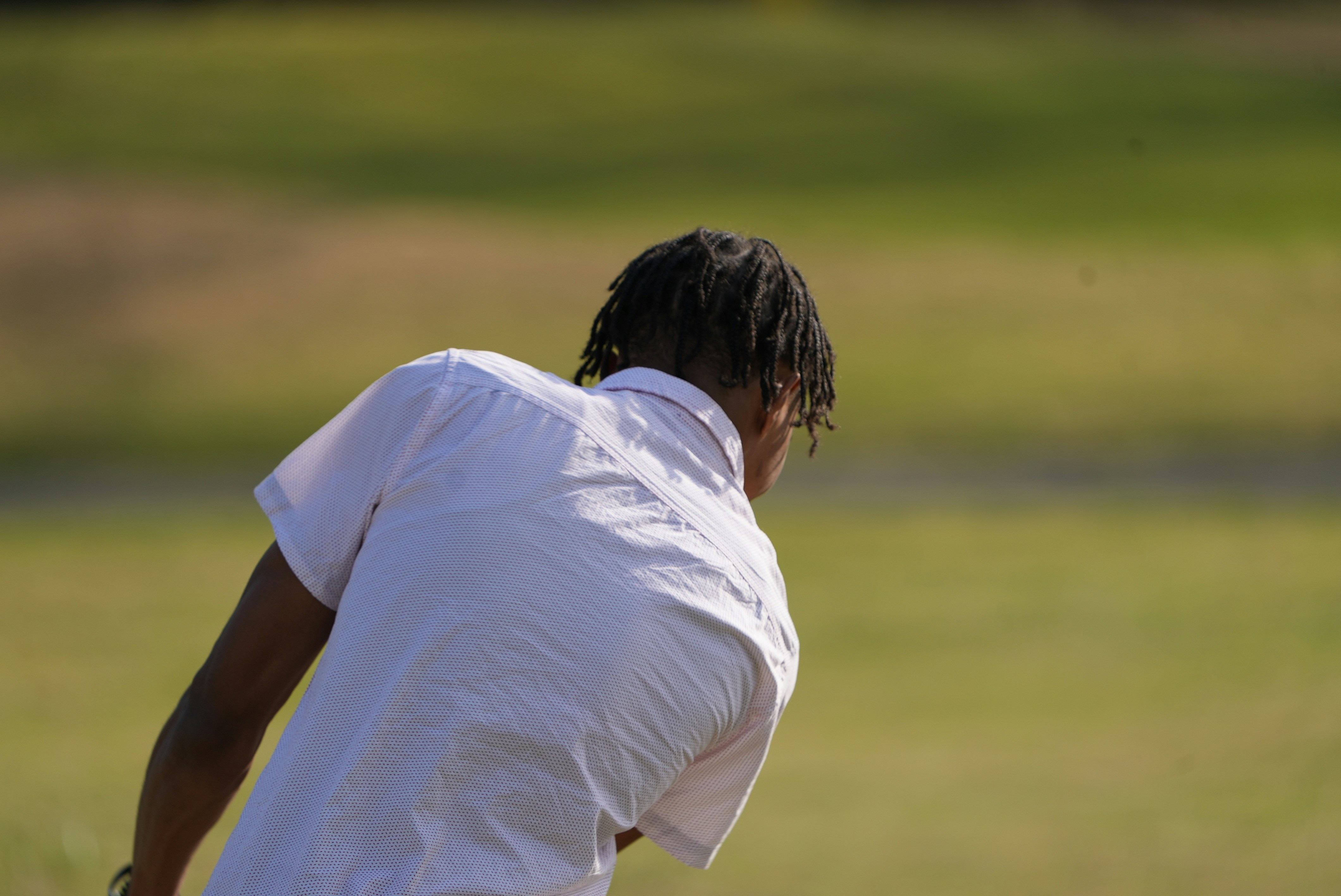 Foto zum Thema Ein Mann mit Dreadlocks steht auf einem Feld ...