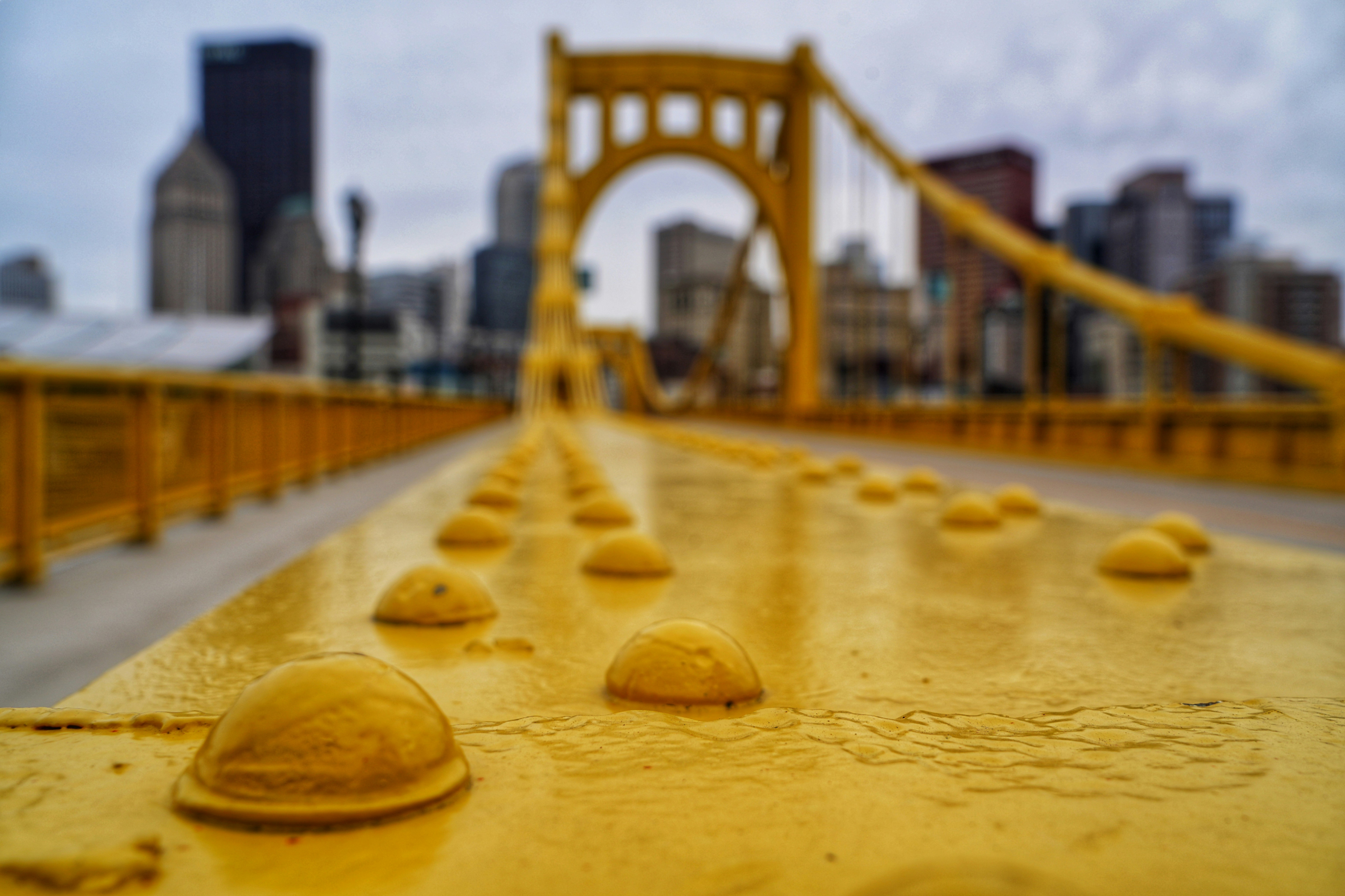 Rivets on a Yellow Bridge: Leading Lines Toward a Blurred Skyline