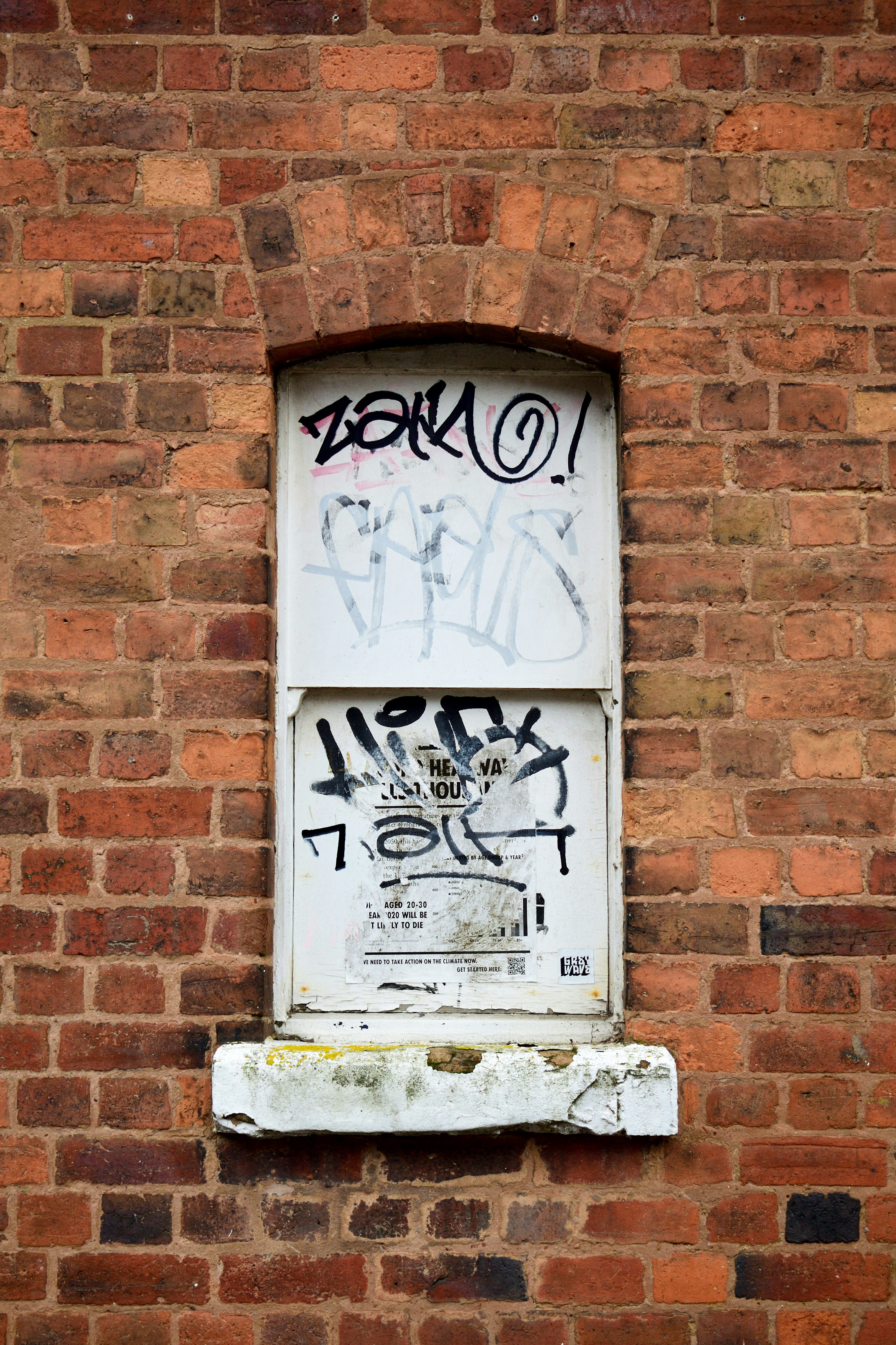 A brick wall with a window with graffiti on it photo – Free Uk Image on ...