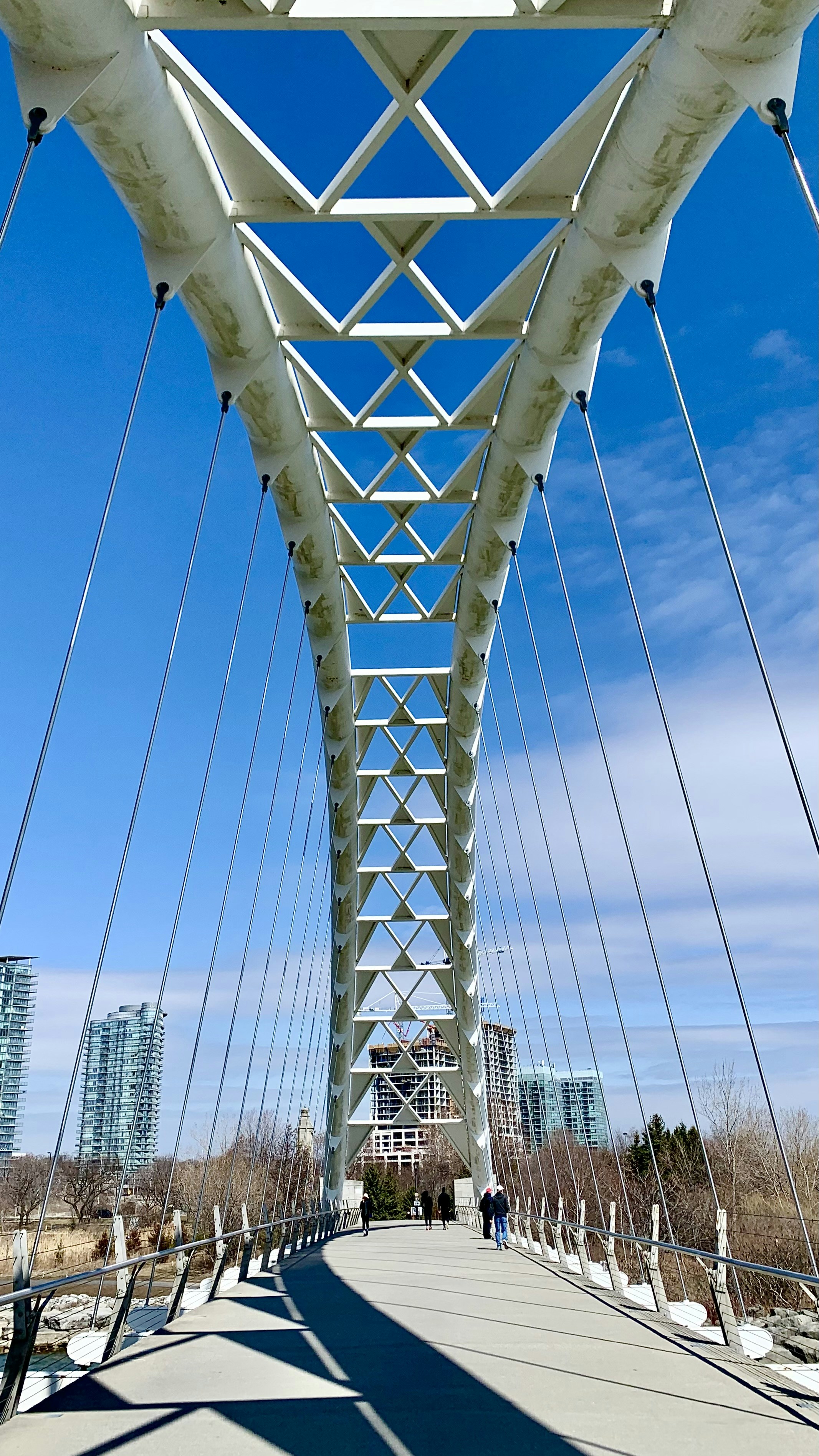 A view of a bridge with people walking across it photo – Free Blue ...