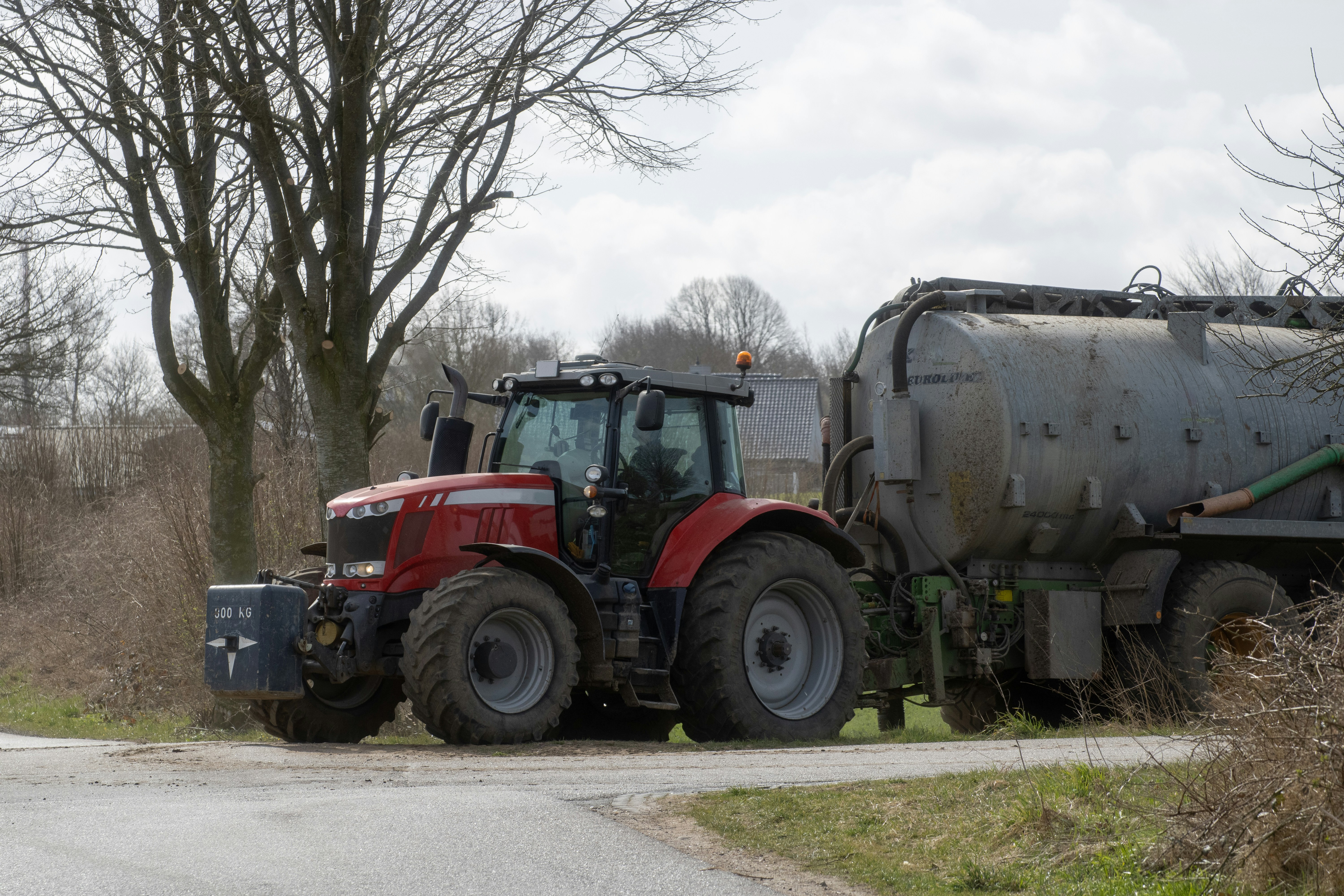Foto zum Thema Ein Traktor ist neben einem großen LKW geparkt ...