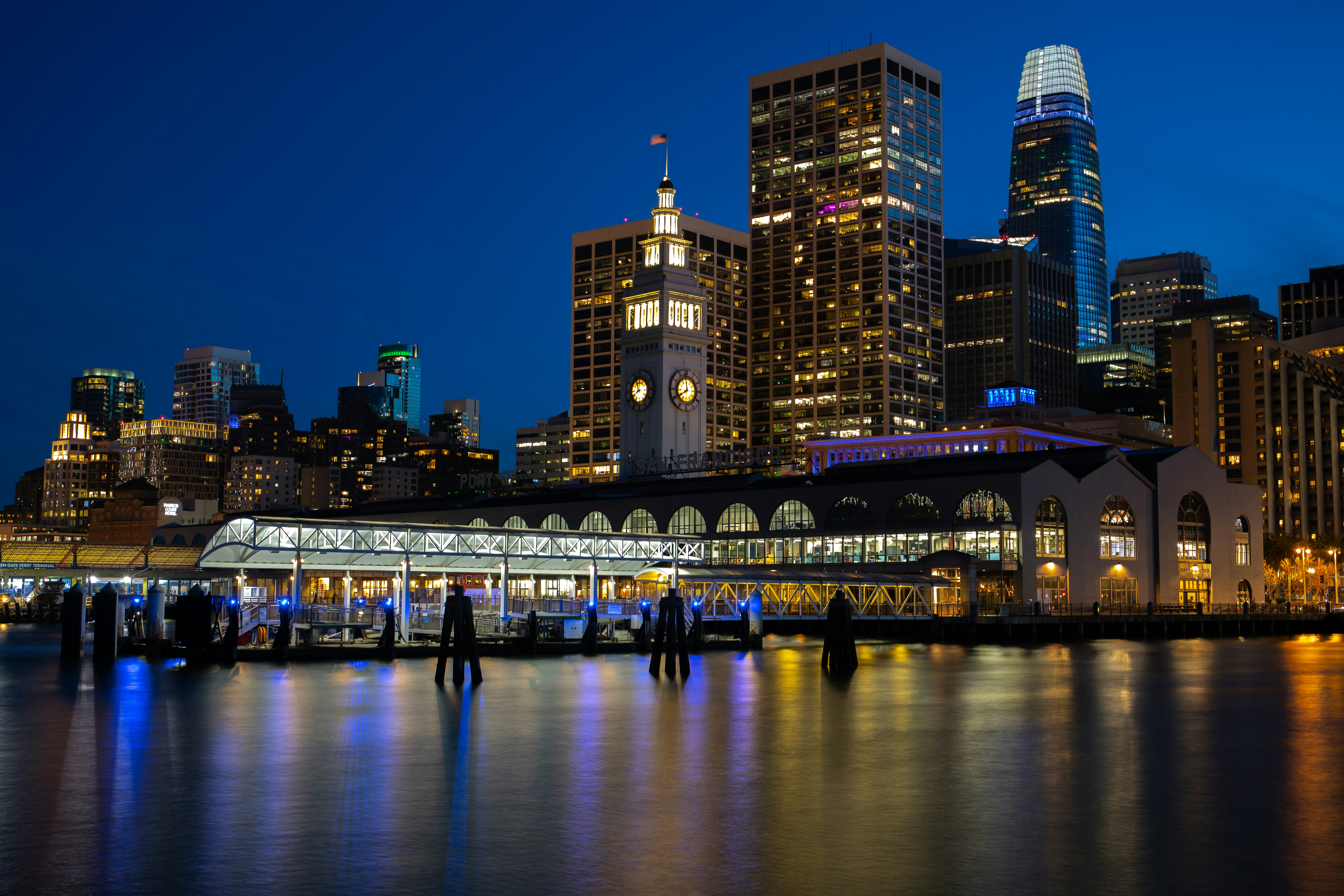 A city skyline at night with a lit up train station photo – Free Ferry ...