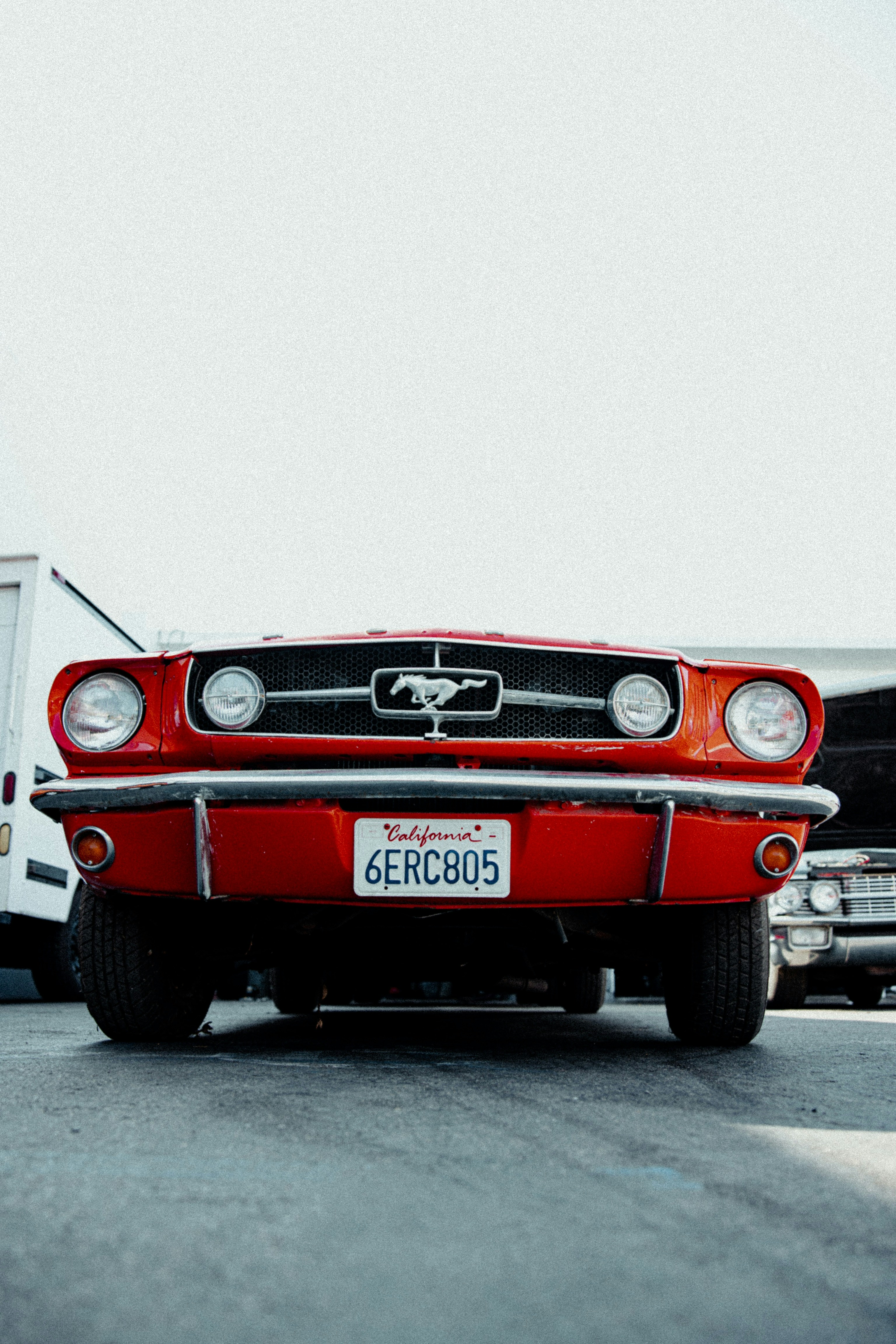 Low-Angle Front View: Red 1960s Mustang in a Quiet Lot