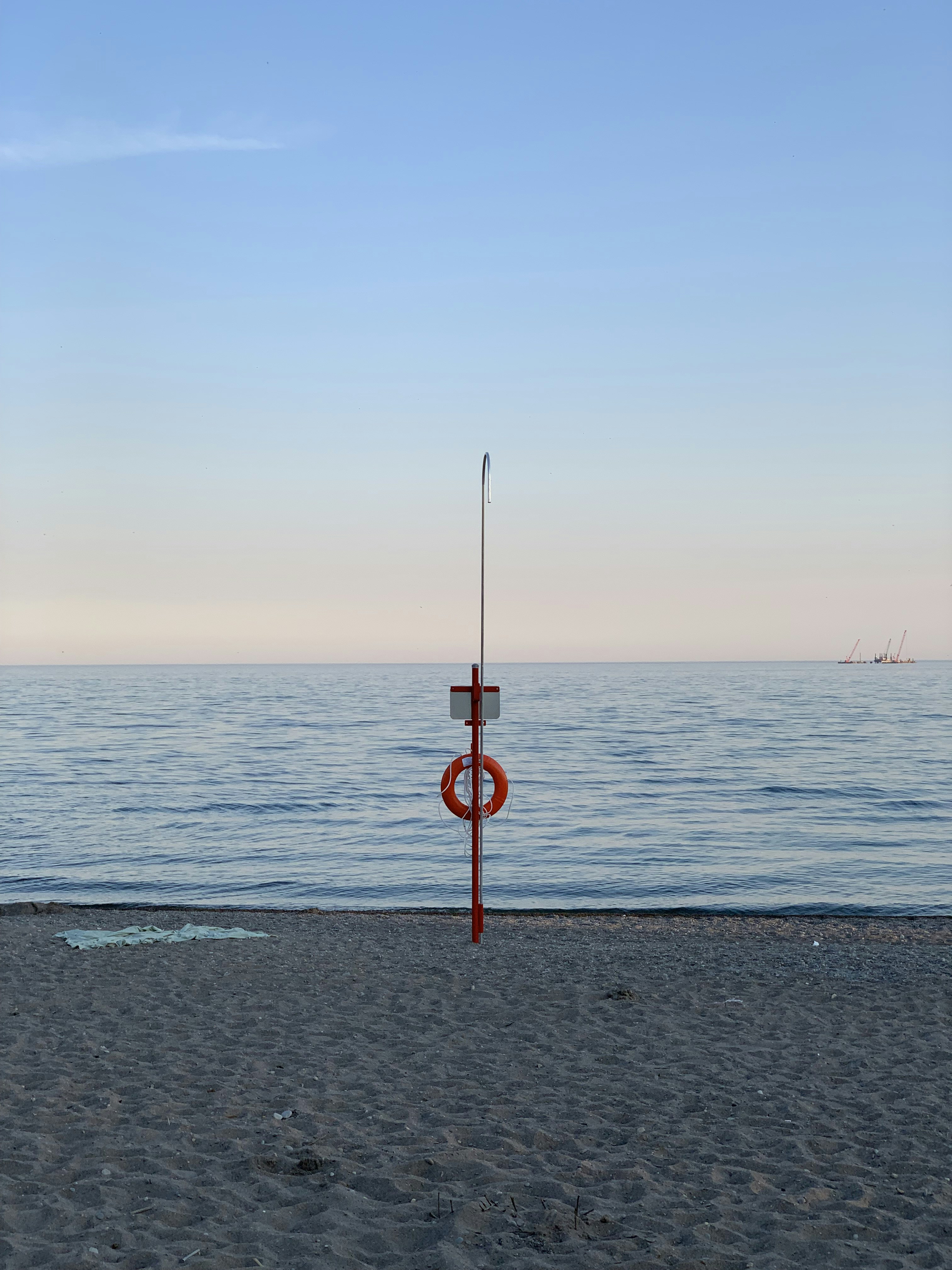 a pole on a beach with the ocean in the background