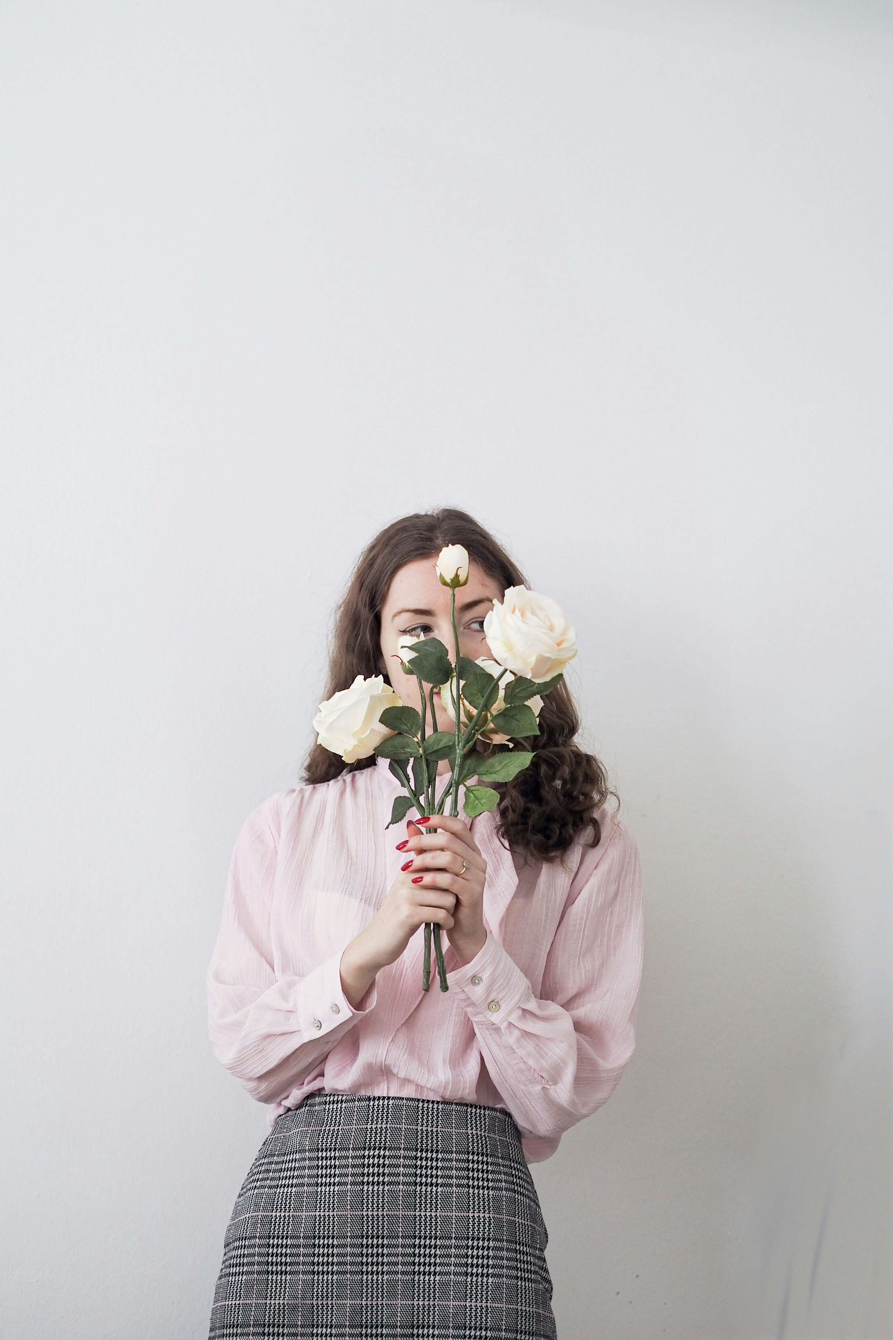 A woman holding a rose up to her face photo – Free Plant Image on Unsplash