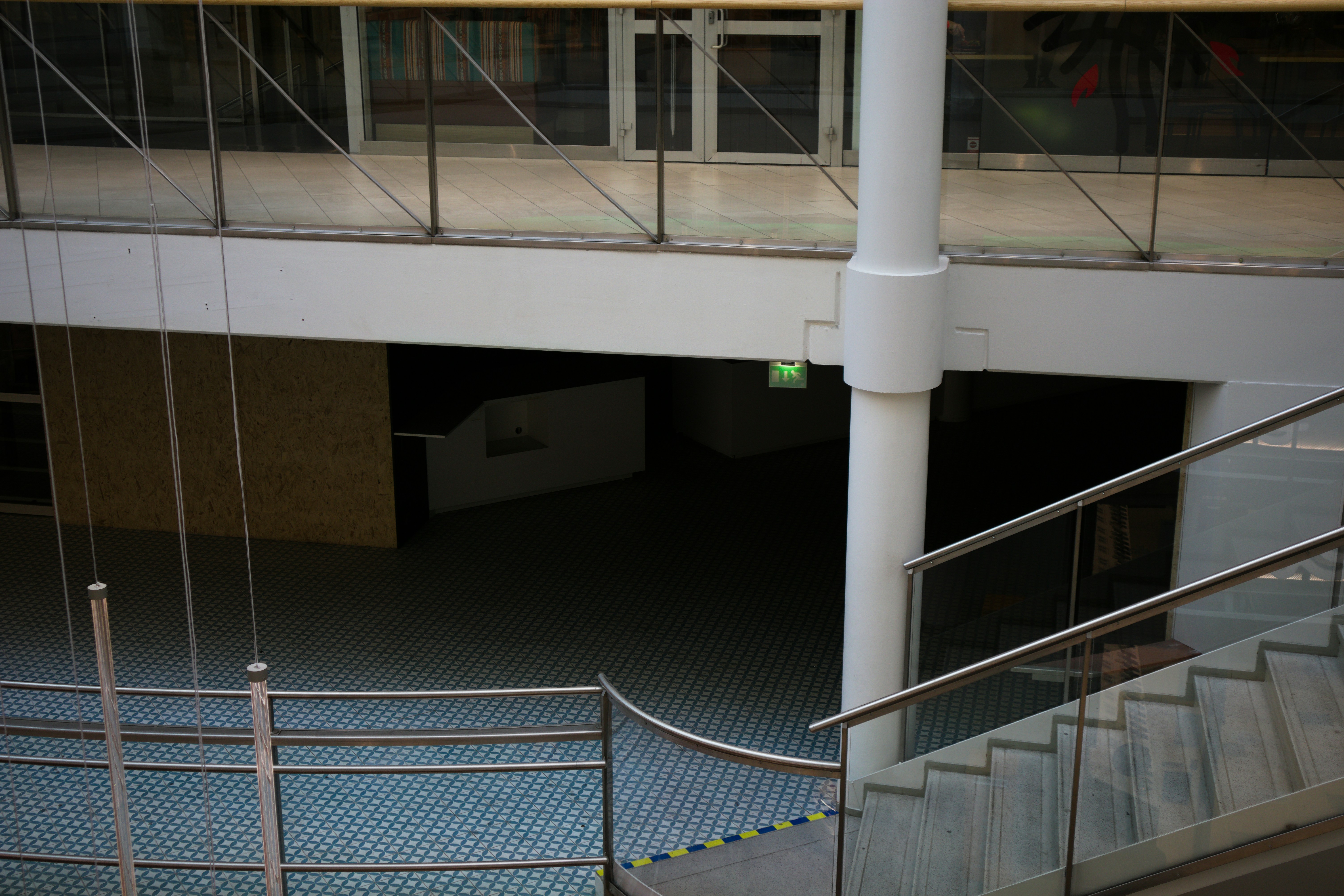 Empty stairwell in a modern building with a clock adorning the wall.