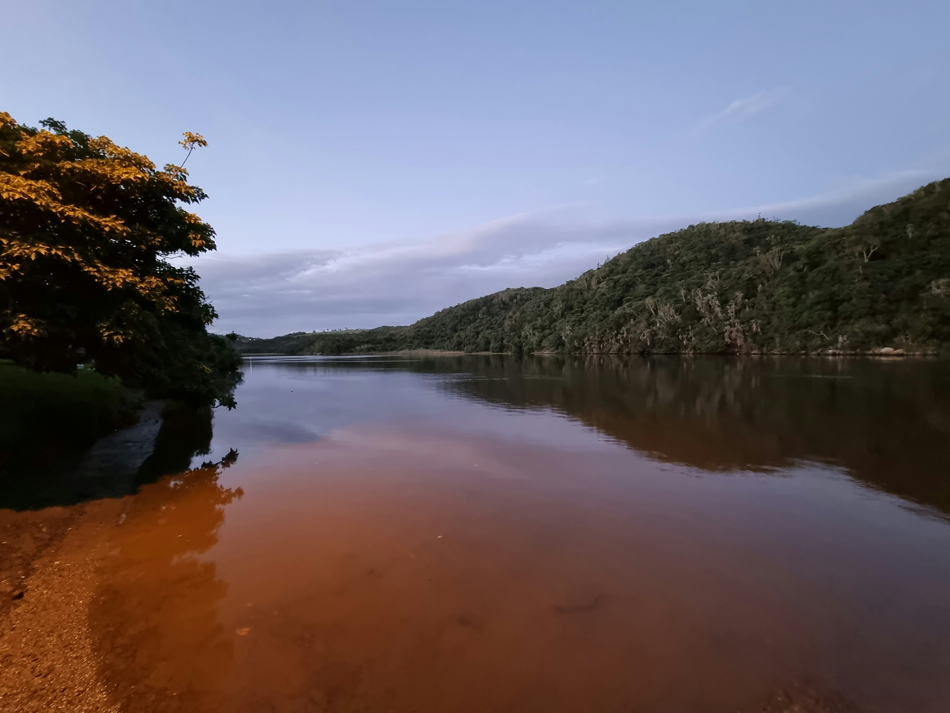 Dusk Along a River Bend: Orange Light Framing Quiet Hills