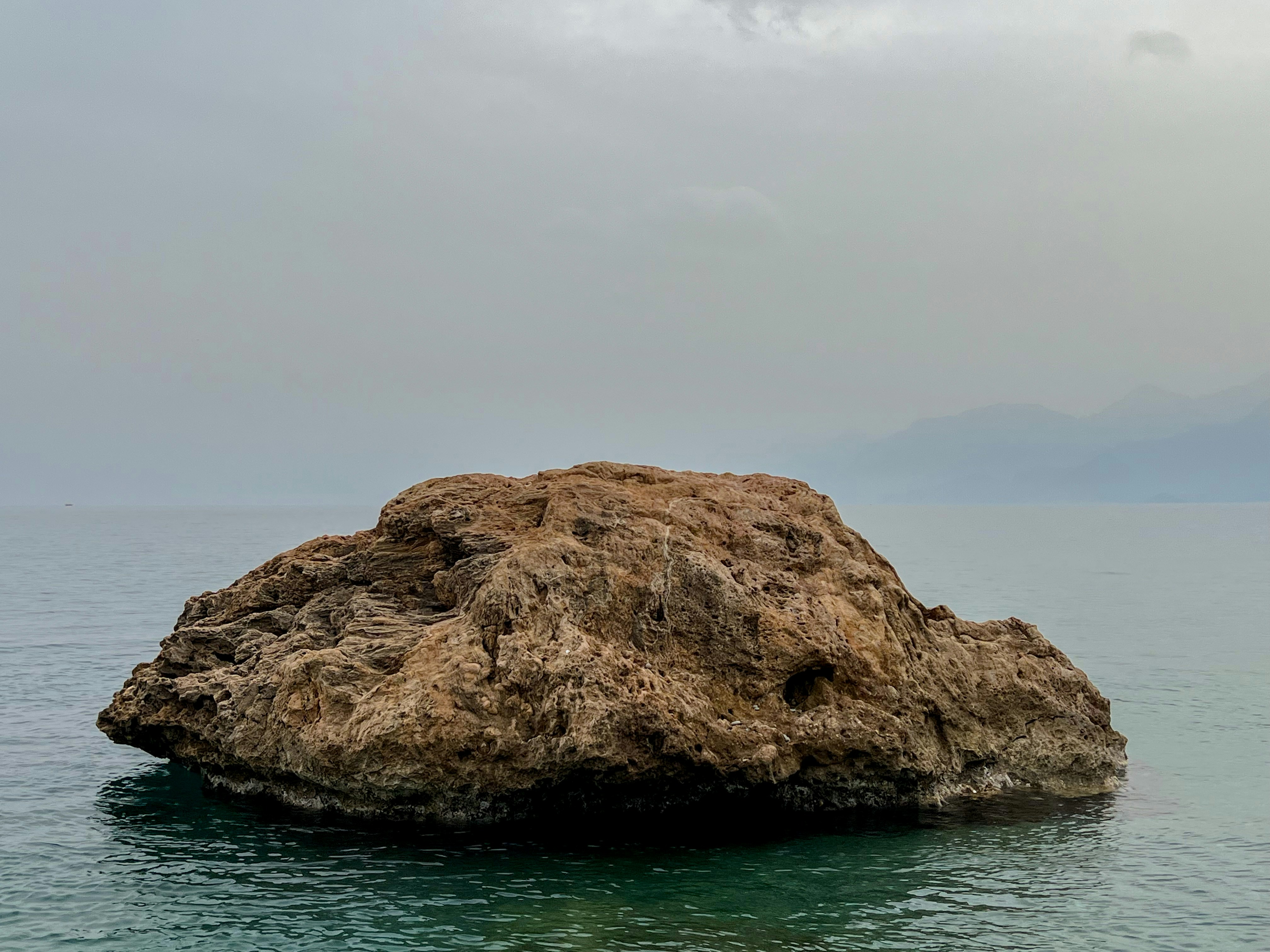 Un gros rocher assis au milieu d’un plan d’eau photo – Photo Gris ...