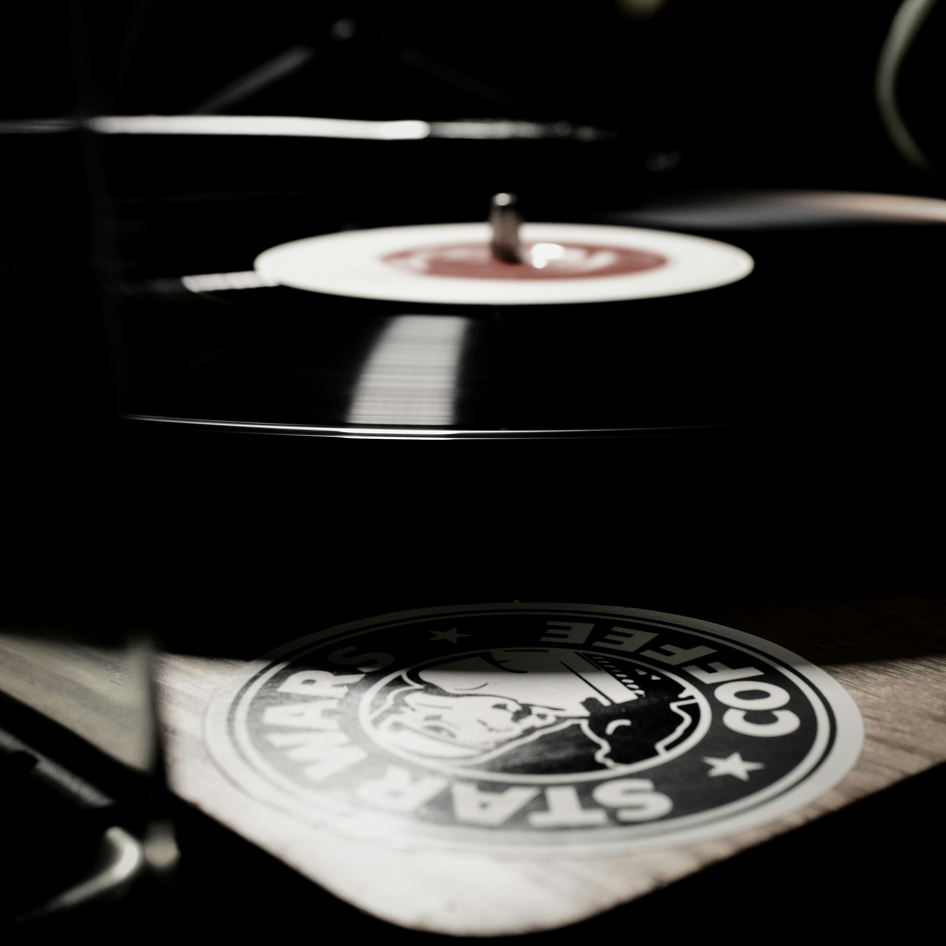 Noir Spin: A Vinyl in Focus on a Dim Studio Turntable