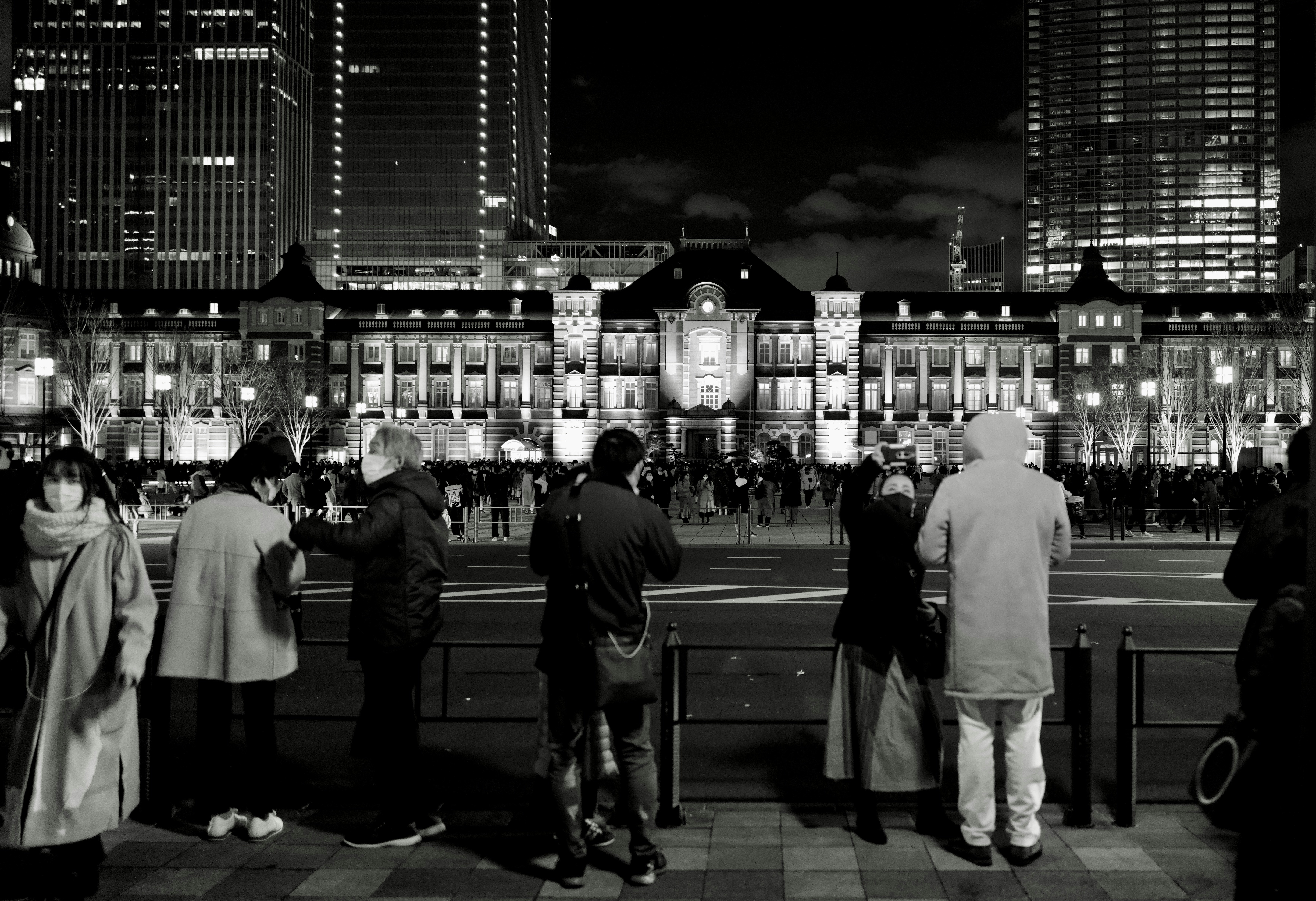 Night crowd at Tokyo Station Square in monochrome