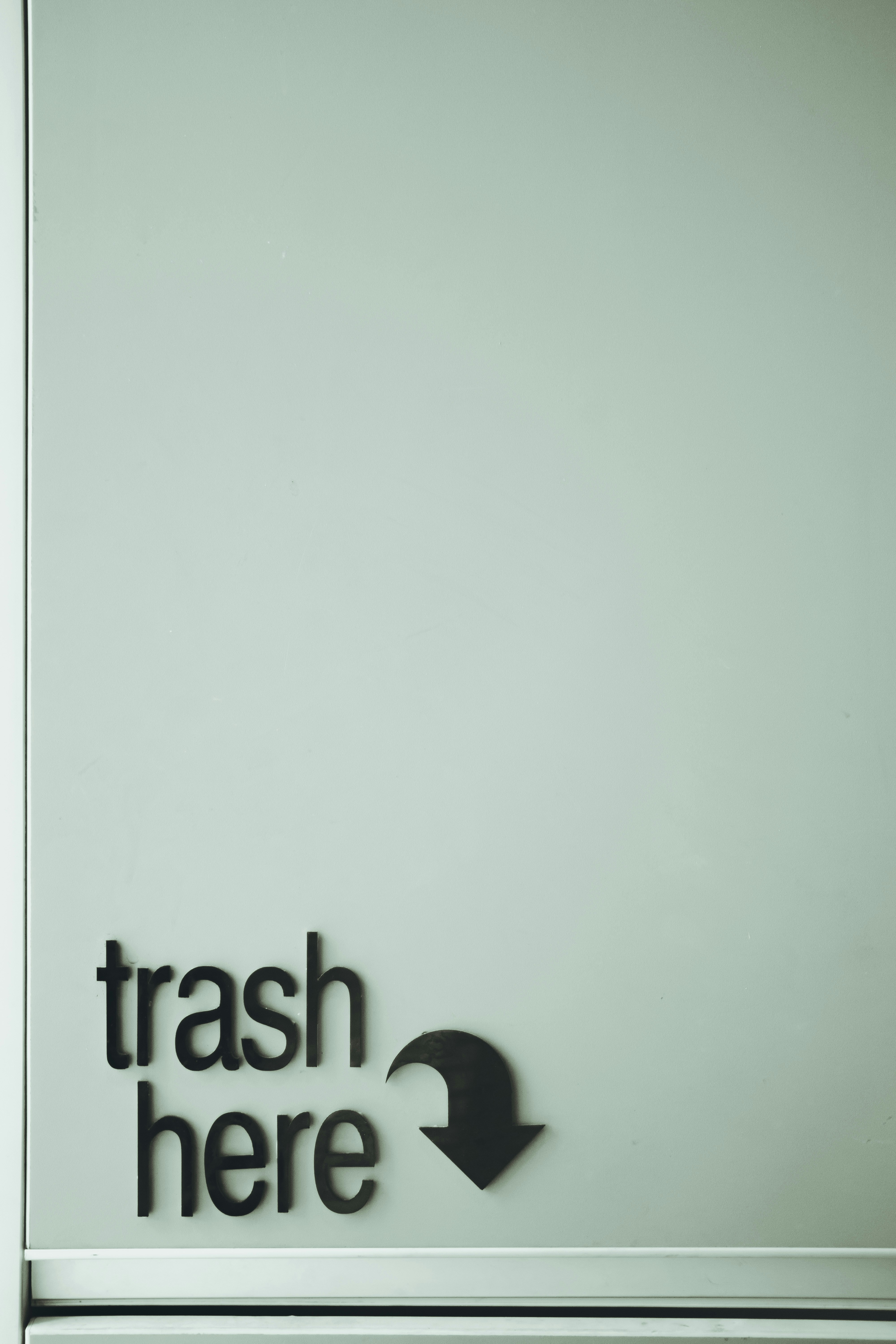 A sign that says trash here on a wall photo – Free Text Image on Unsplash