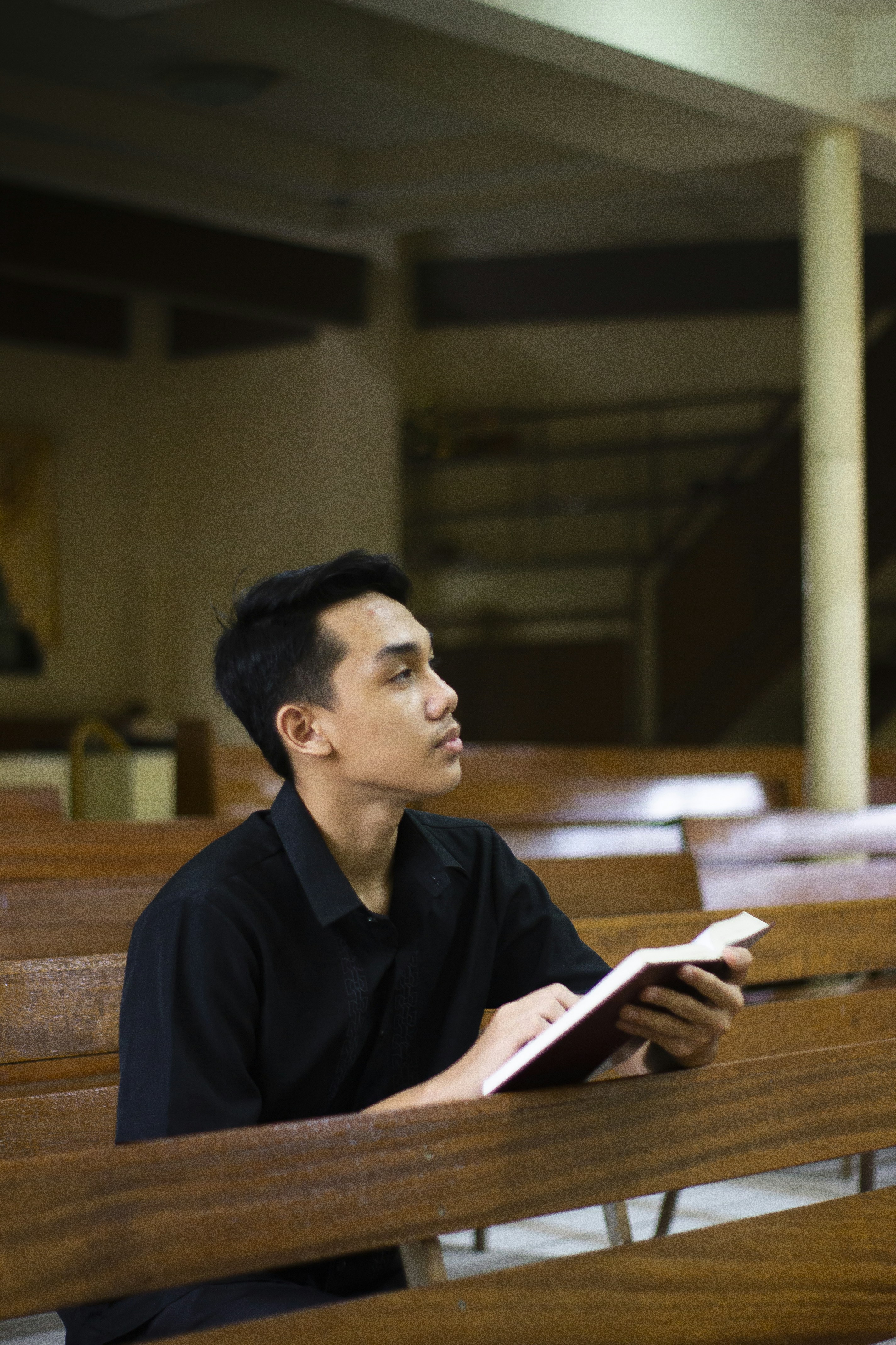A man sitting in a pew reading a book photo – Free Wood Image on Unsplash