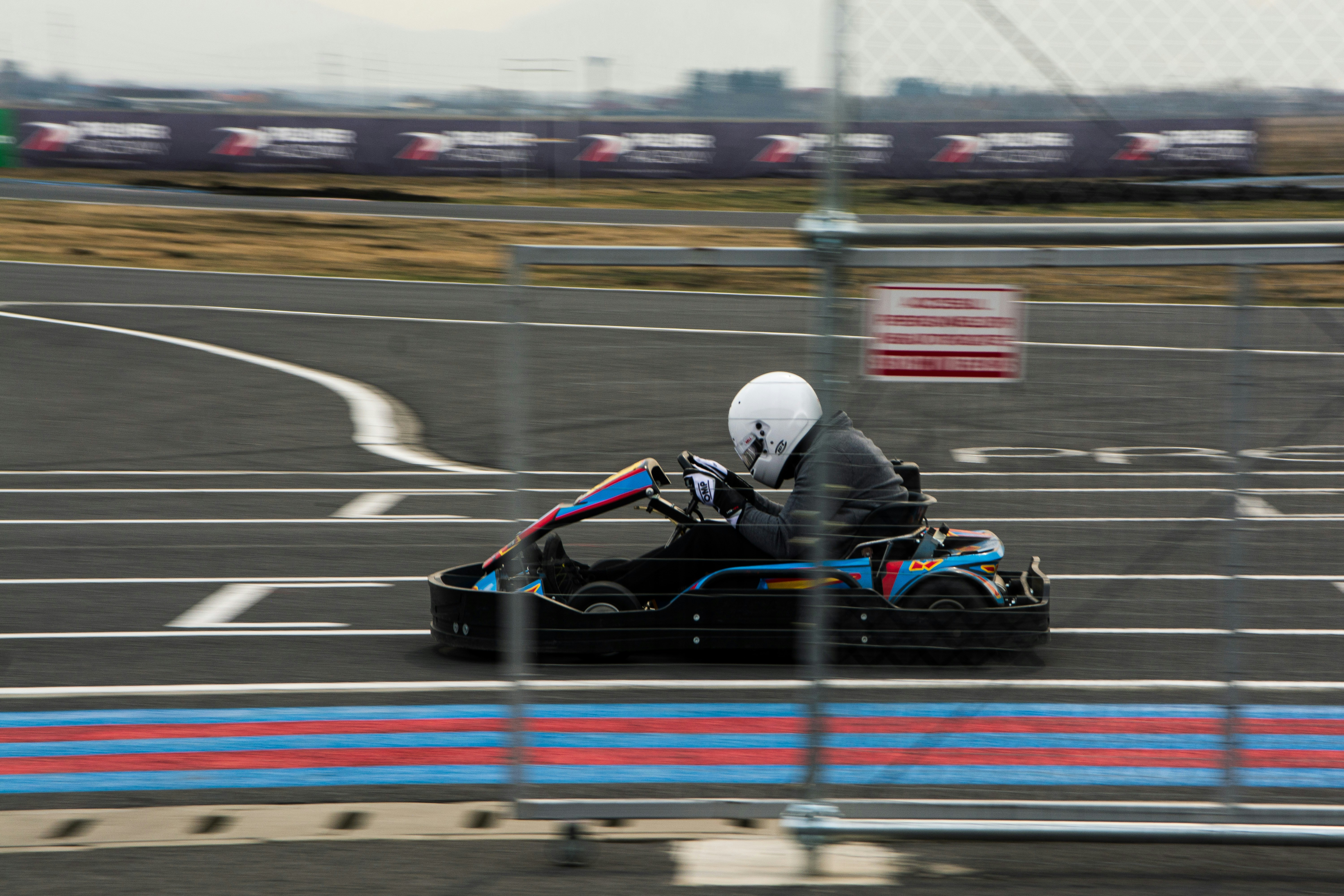 Go-kart speeding along a track with a blurred background, highlighting motion.