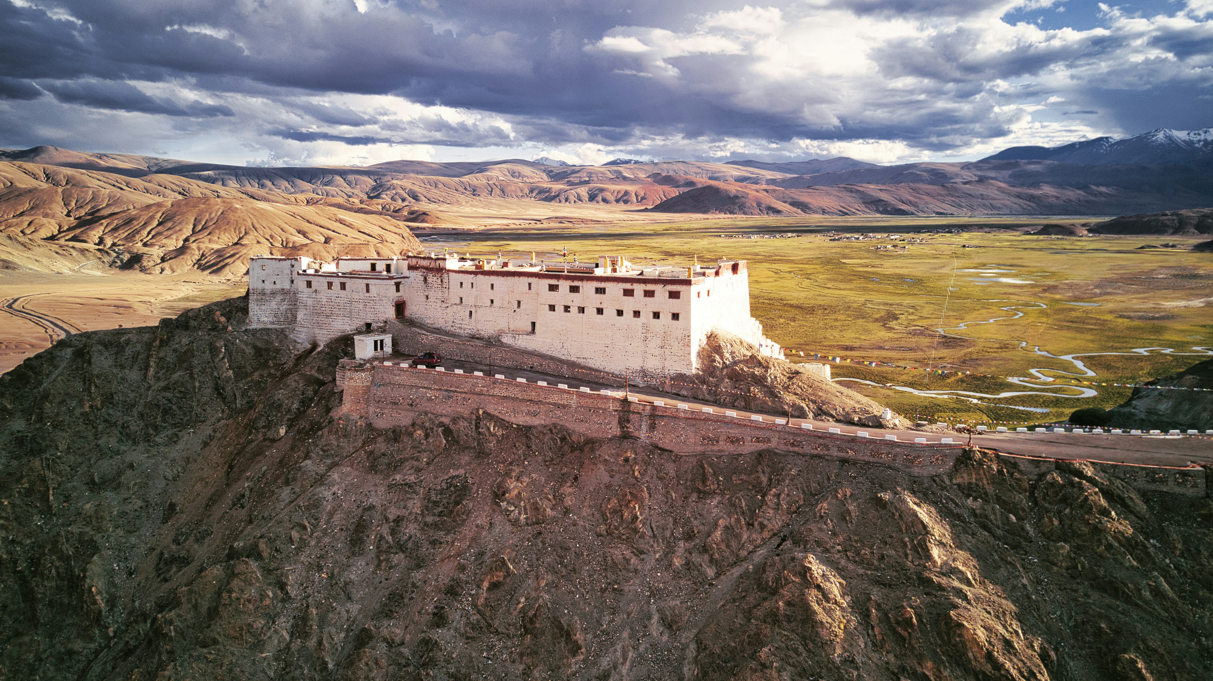 Cliffside Citadel Bathed in Desert Light Over a Winding Plain