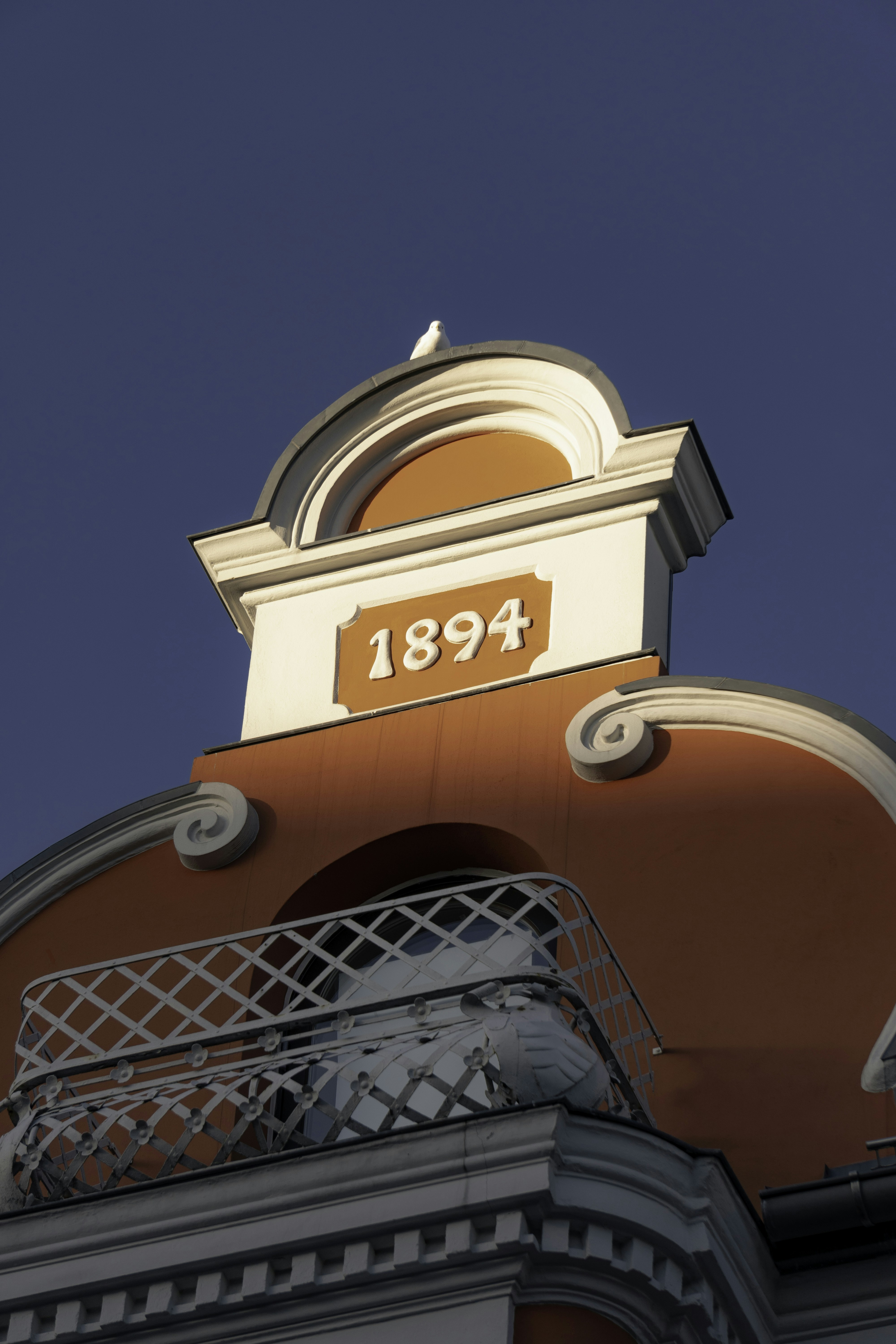 1894 on a Baroque Revival Facade: Sunlit Curves and Lattice Rails