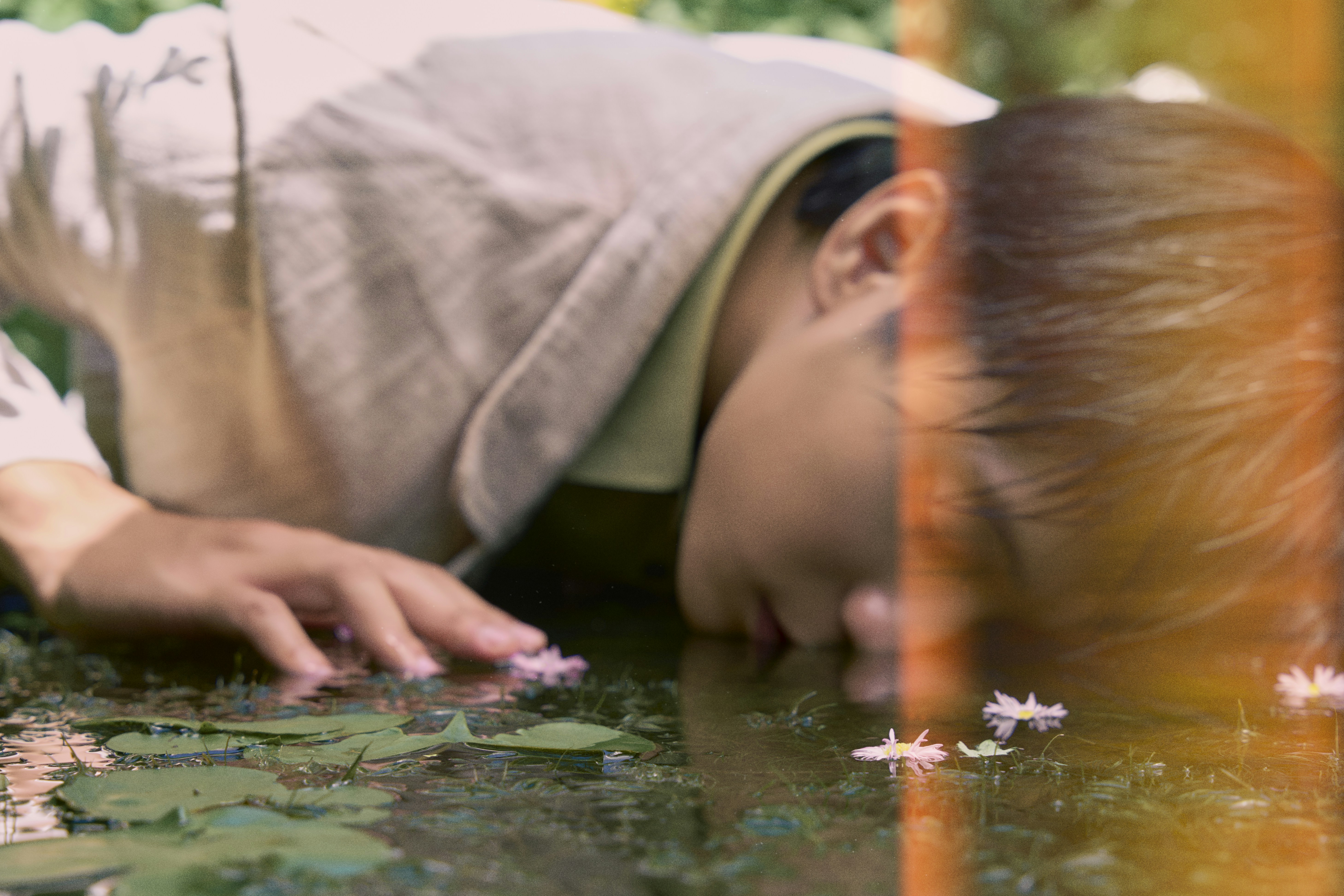 a young boy is playing in a pond of water