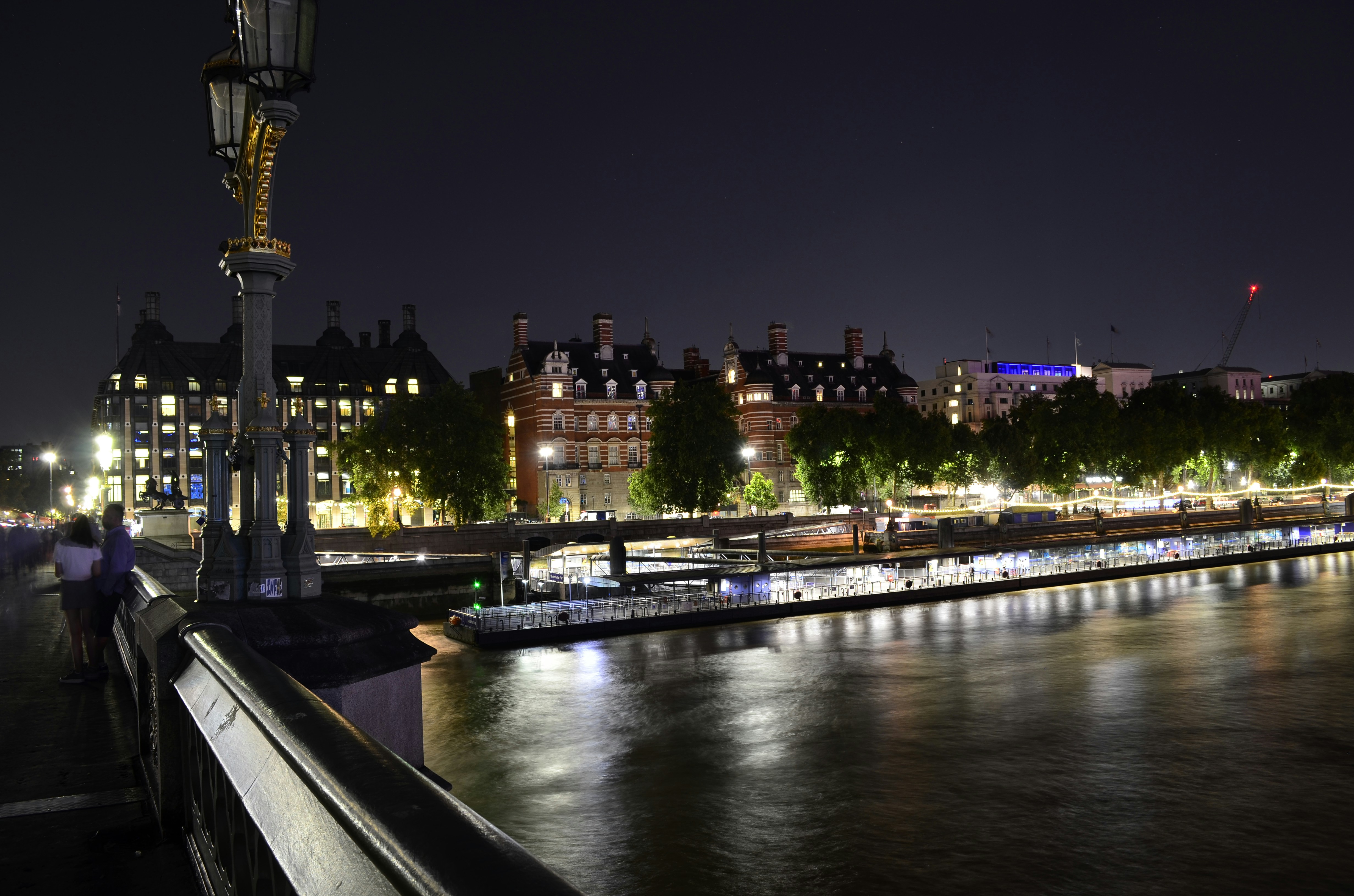 City Lights on the Thames: Nighttime Promenade by the Bridge