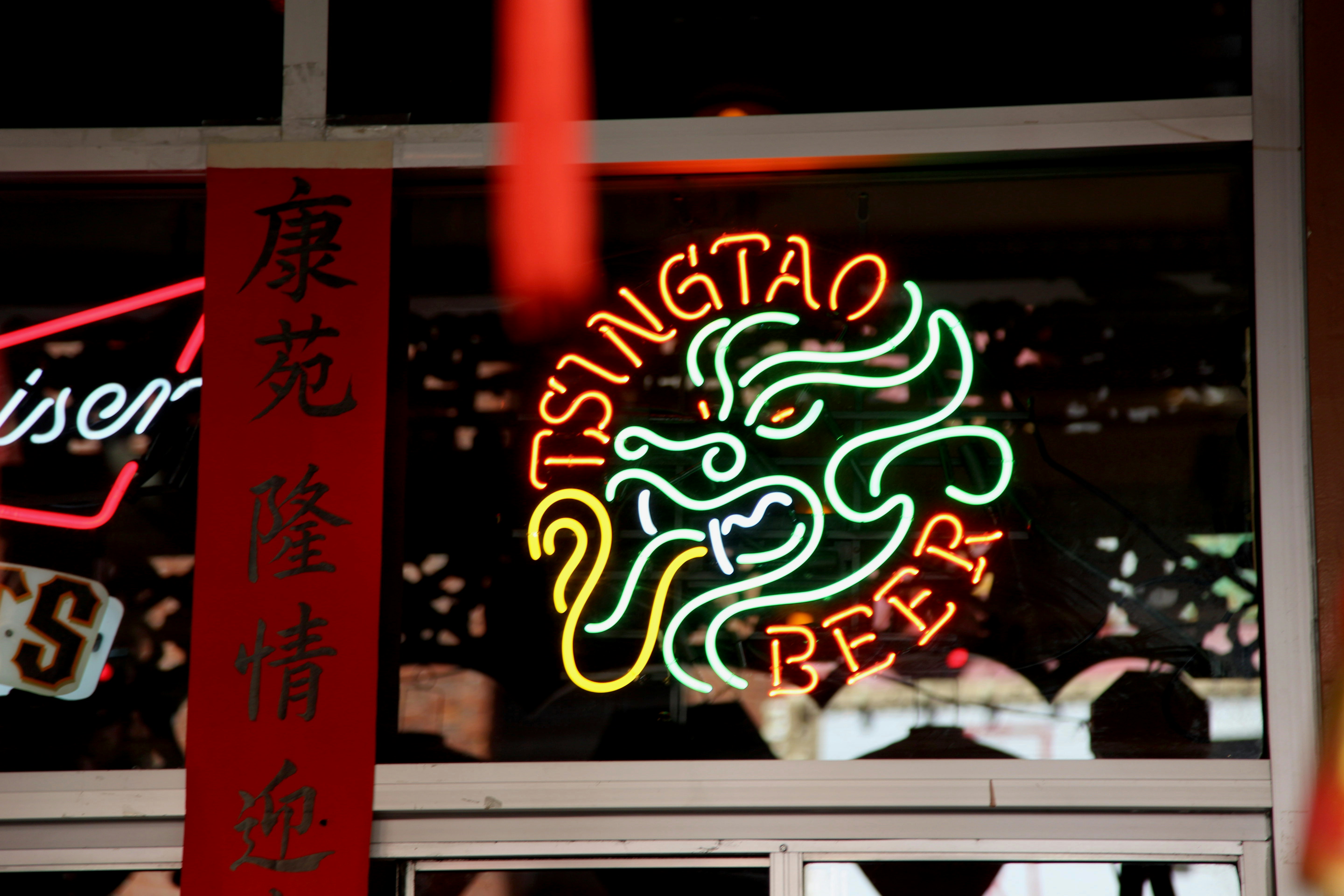 Neon Dragon Over Tsingtao Beer in a Night Window