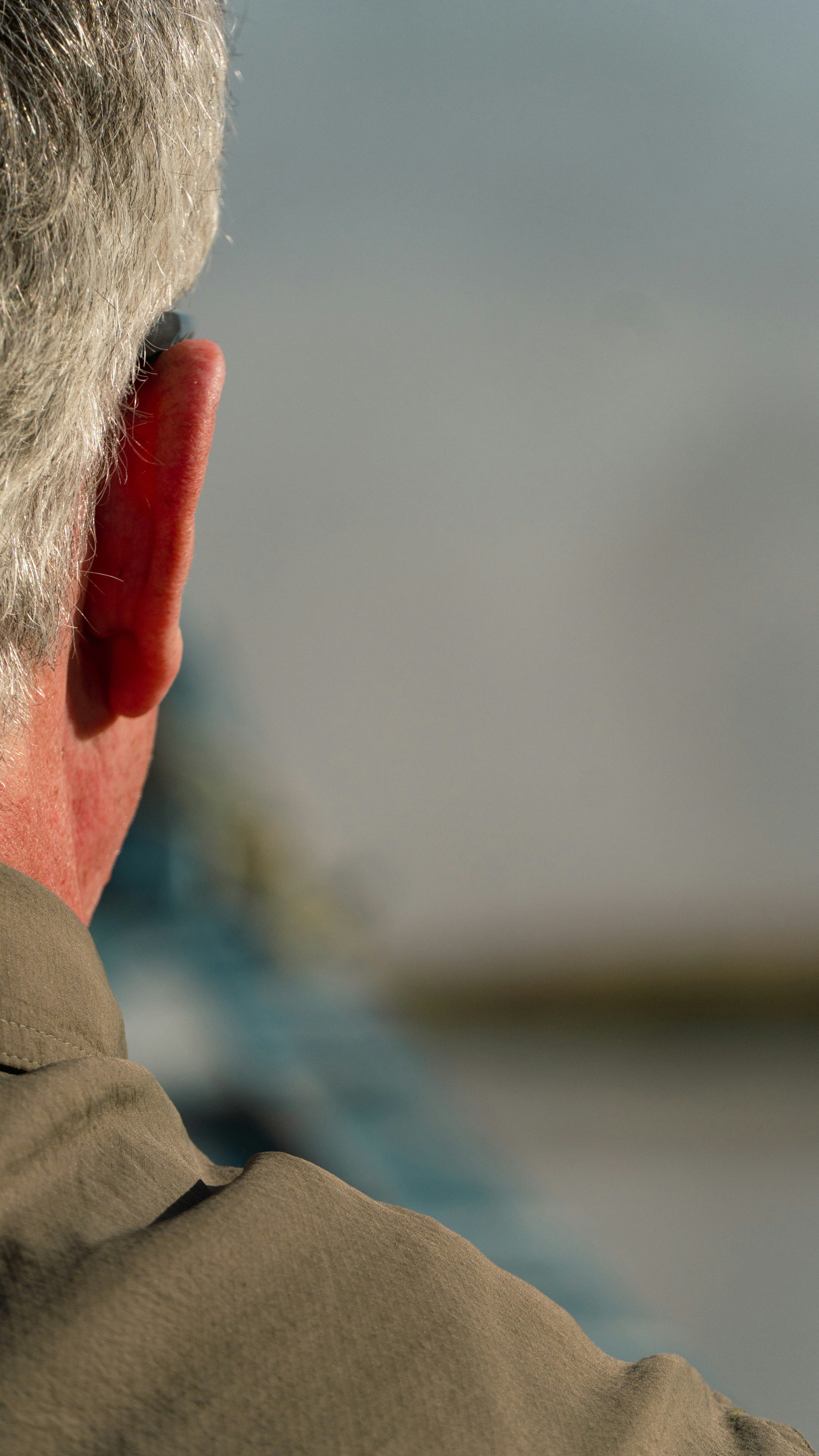 A close up of a man with a cell phone in his ear photo – Free Grey ...
