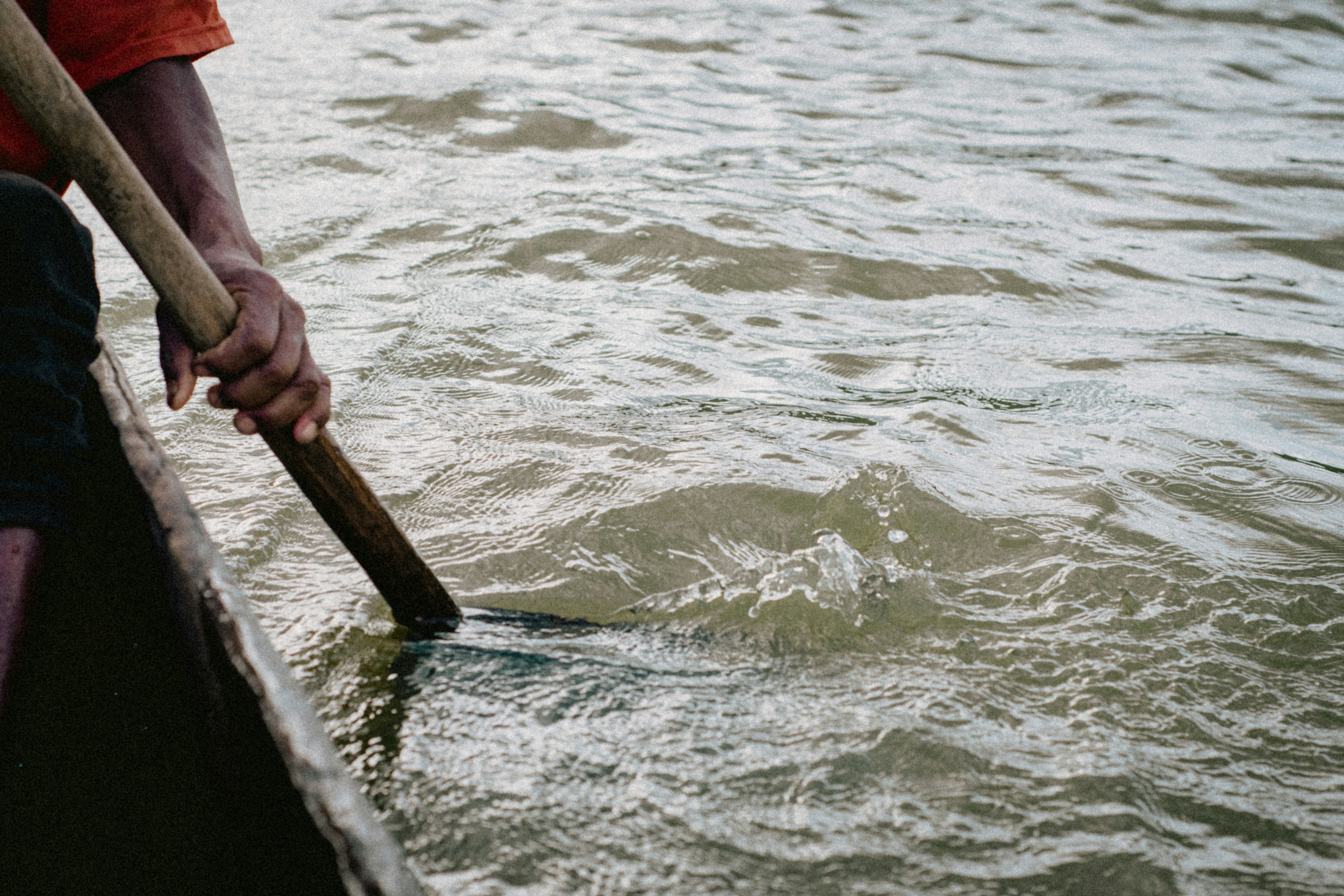 Una persona remando un bote en un cuerpo de agua foto – Imagen de Gris ...
