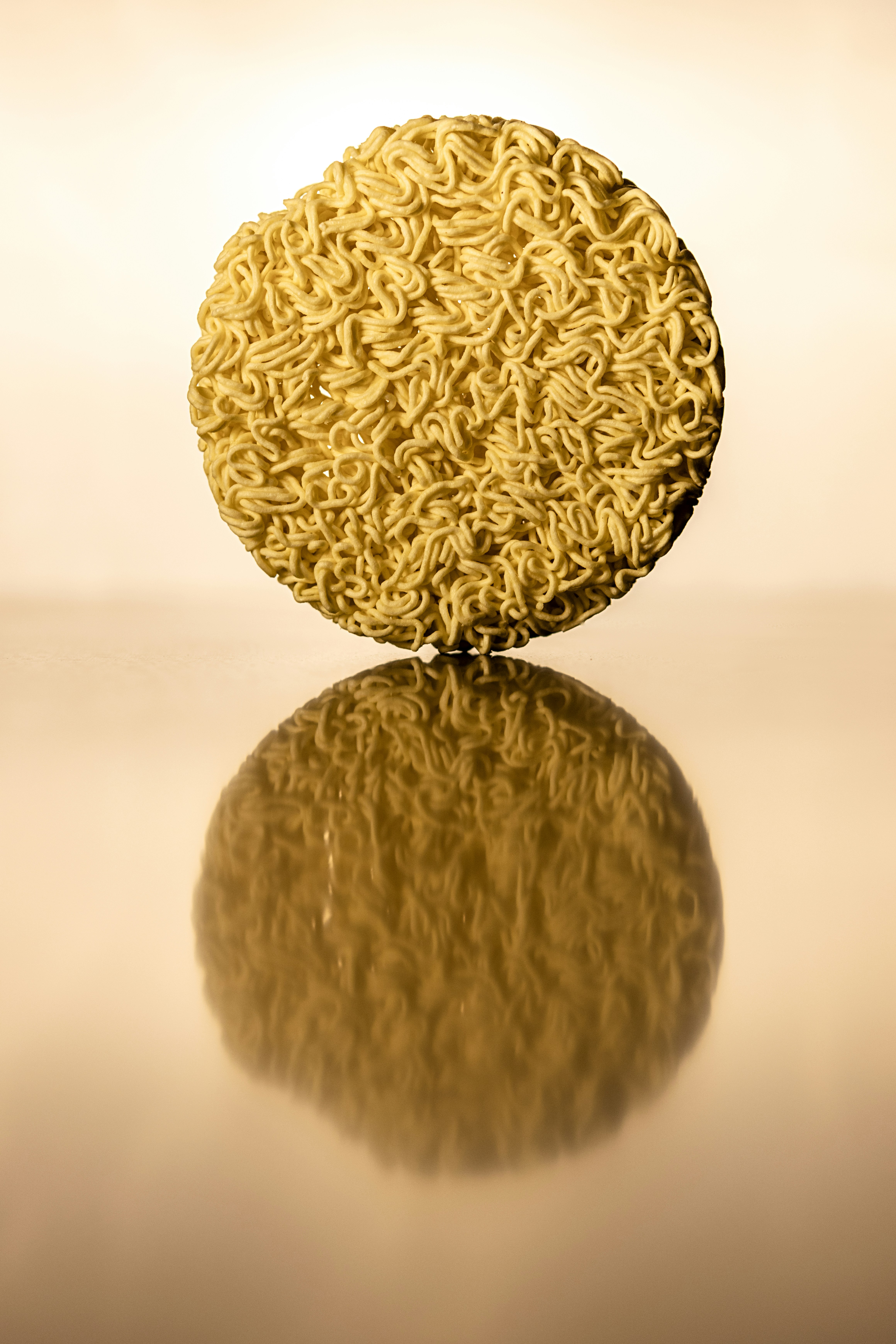 A round object made out of noodles on a reflective surface photo – Free ...