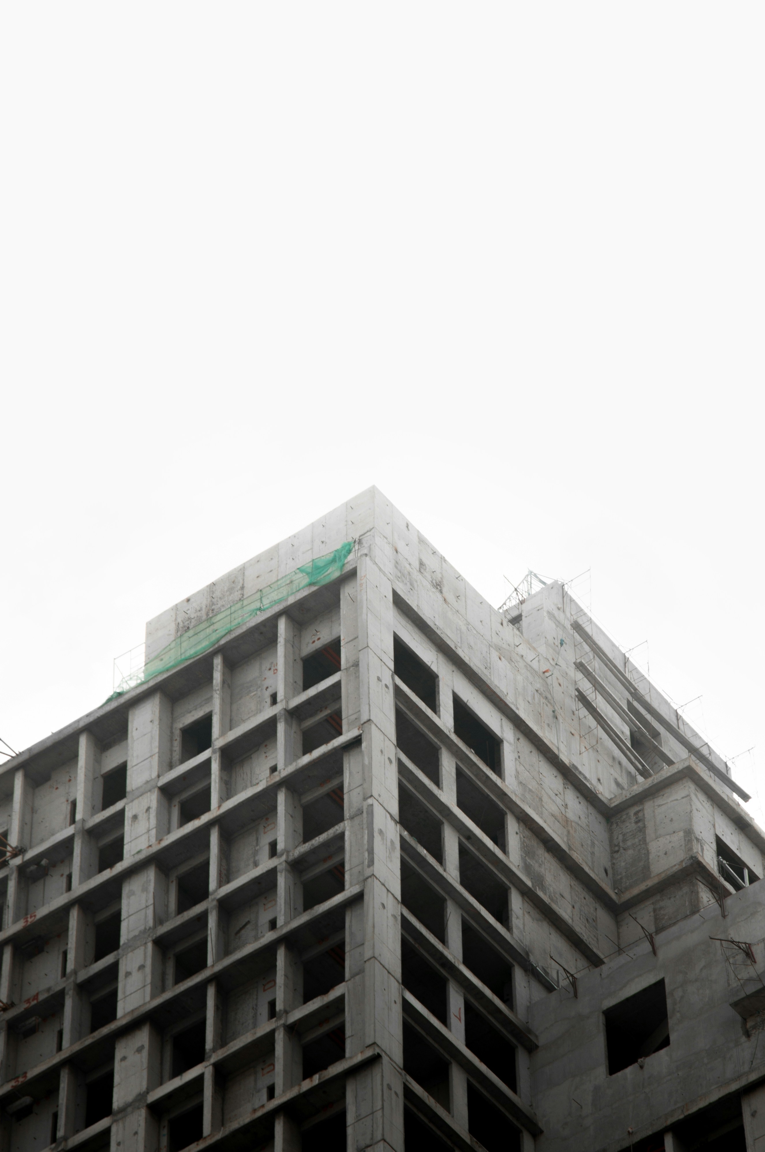 Corner Skeleton: Concrete Grid Reaching Toward the Pale Sky
