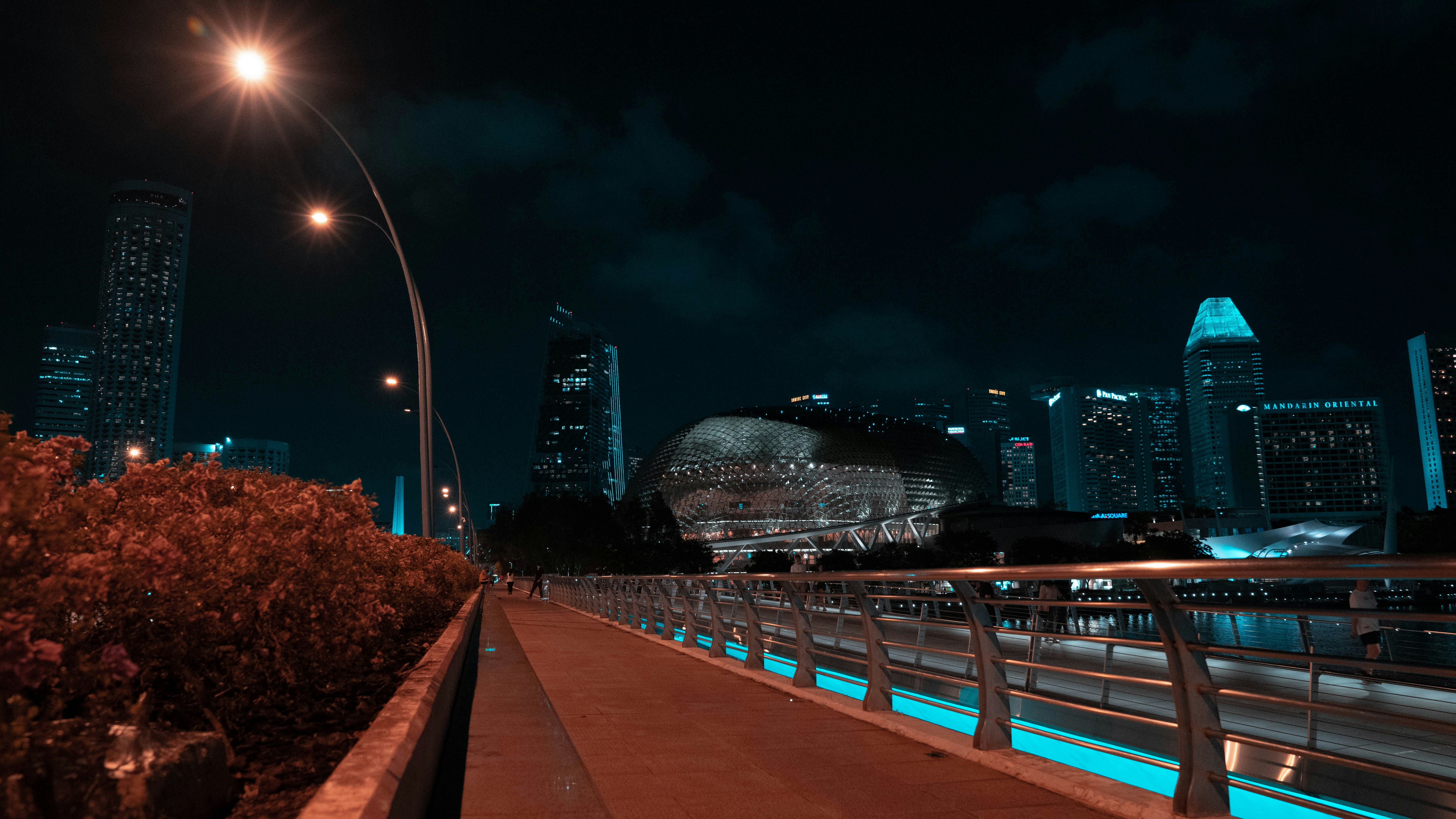 Dramatic city skyline illuminated at night, showcasing modern architecture and vibrant street lighting. The scene captures the essence of urban life after dark.