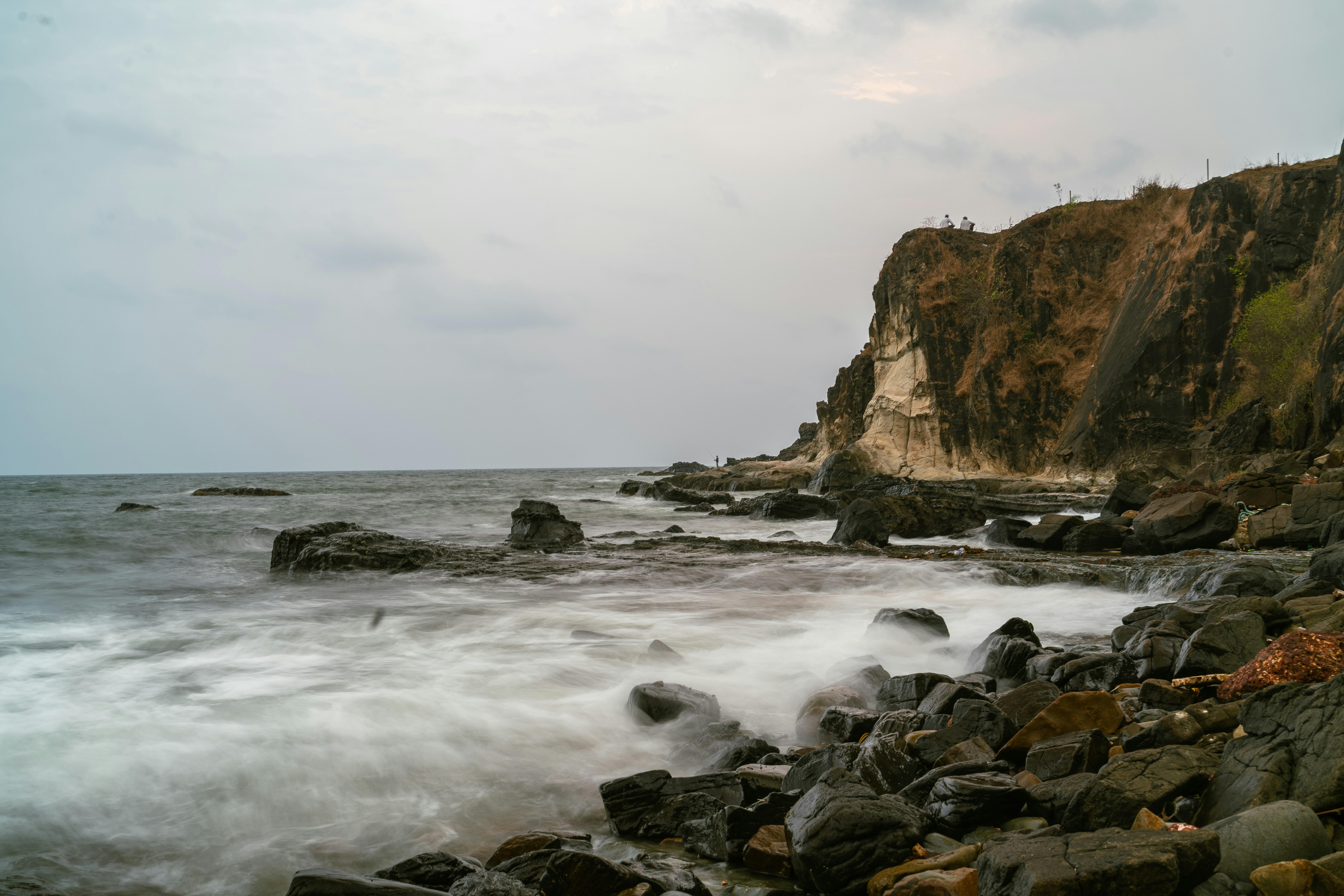 A rocky beach with a cliff in the background photo – Free Goa Image on ...