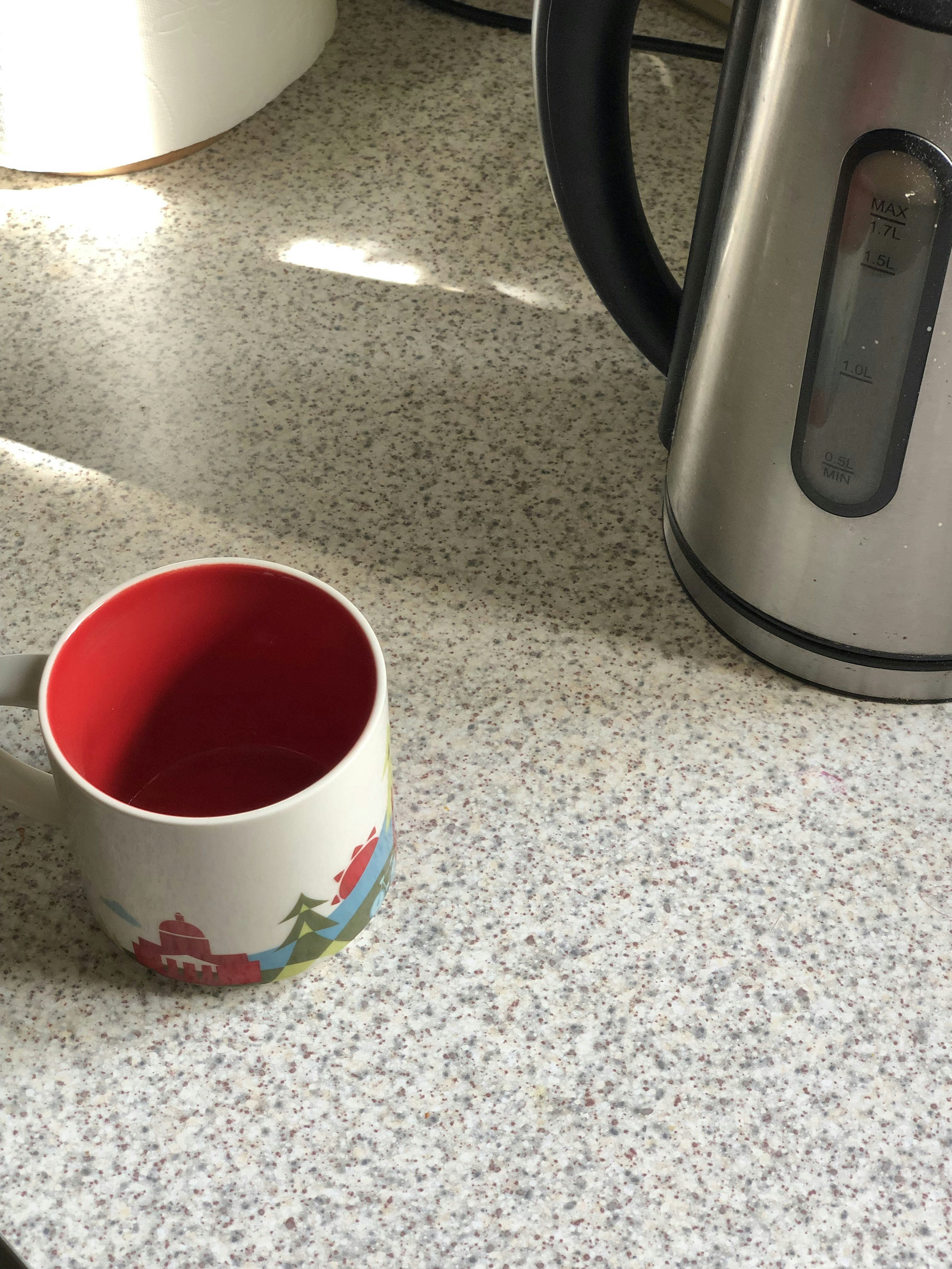 a coffee mug sitting on a counter next to a coffee pot
