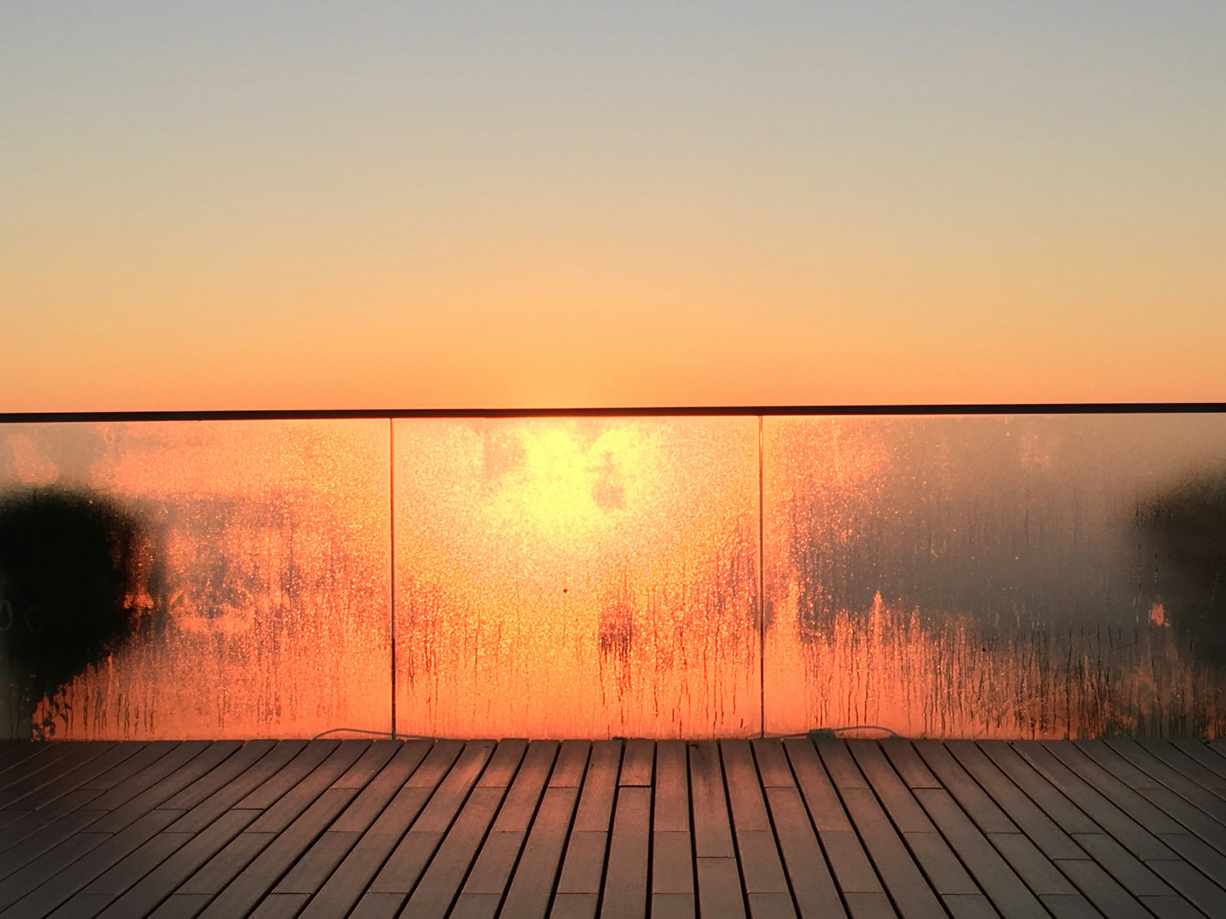 Horizon Glow Through a Frosted Glass Railing at Dusk