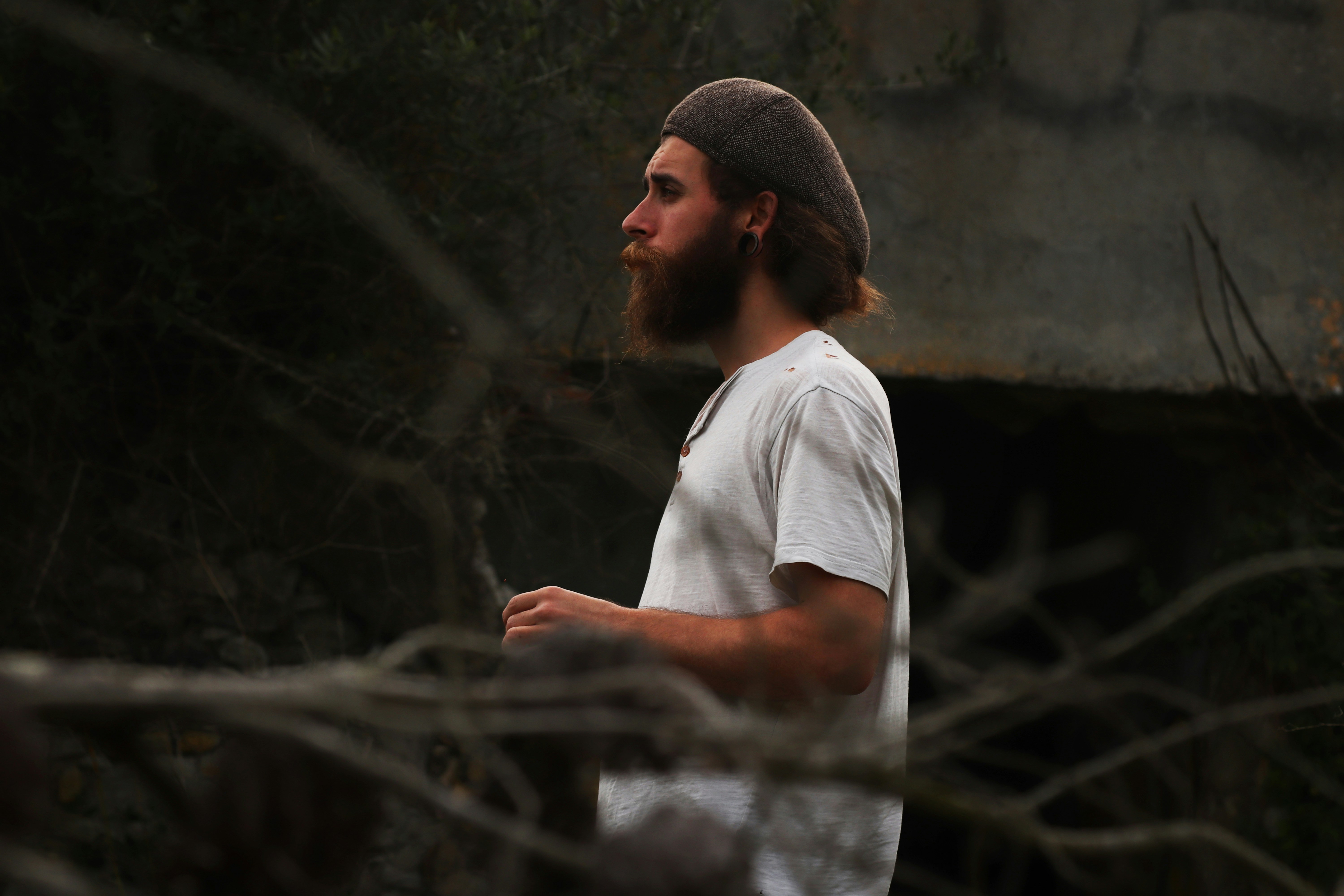 Bearded, smoking man in the ruins of an abandoned building (prison) in Trafaria, Portugal, close to Lisbon. 