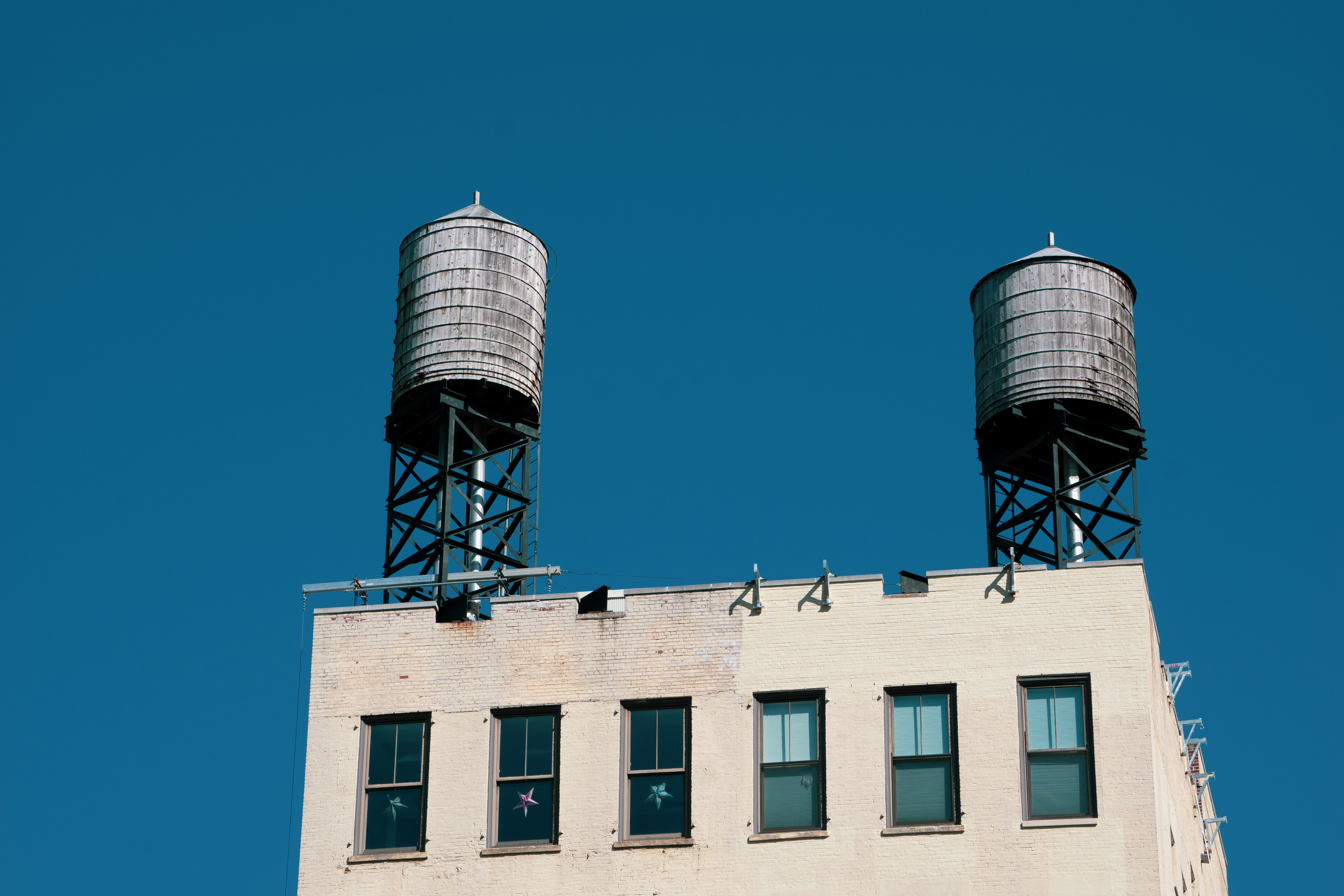 Two water towers on top of a building photo – Free Water tower Image on ...