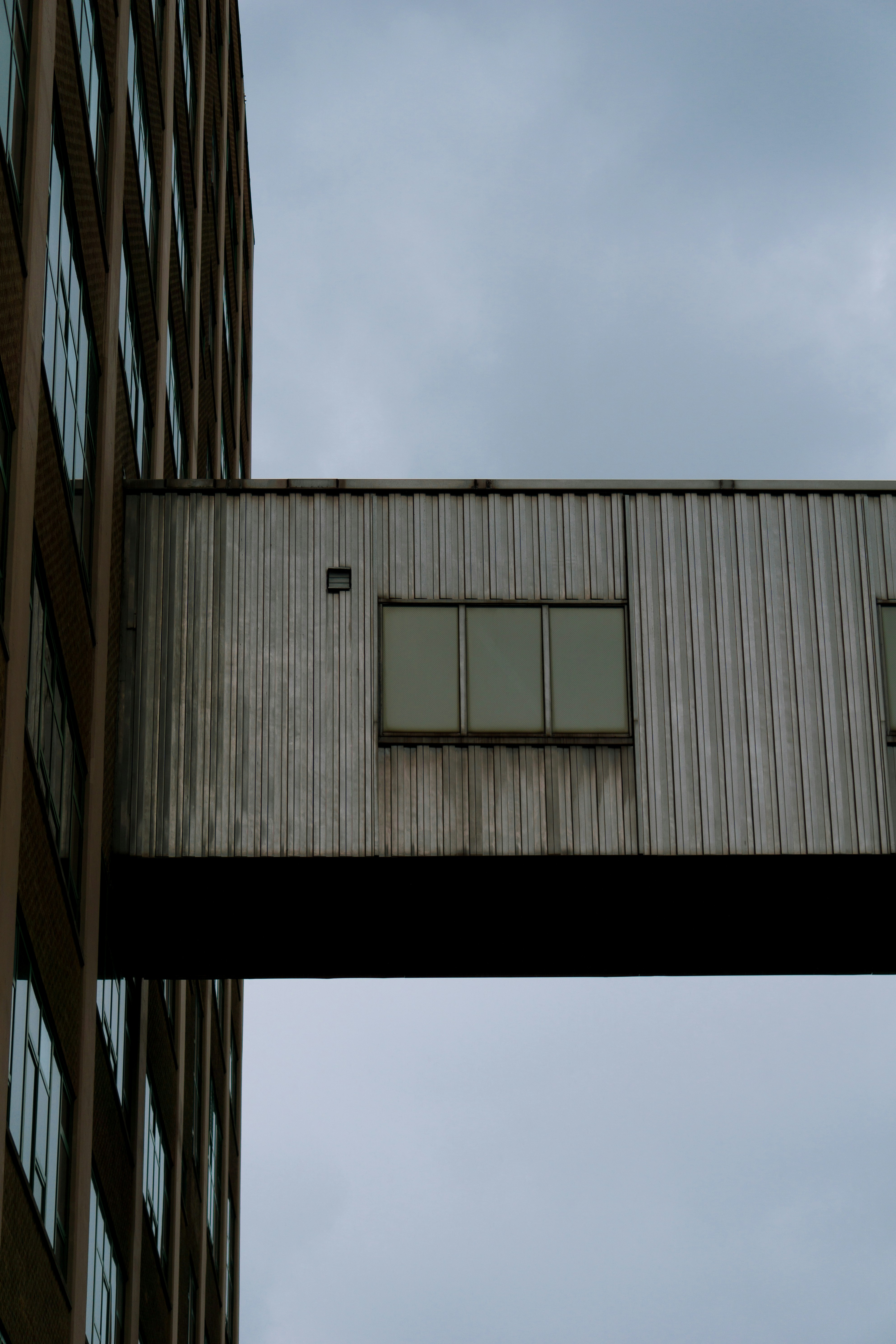 a tall building with a metal roof next to a tall building