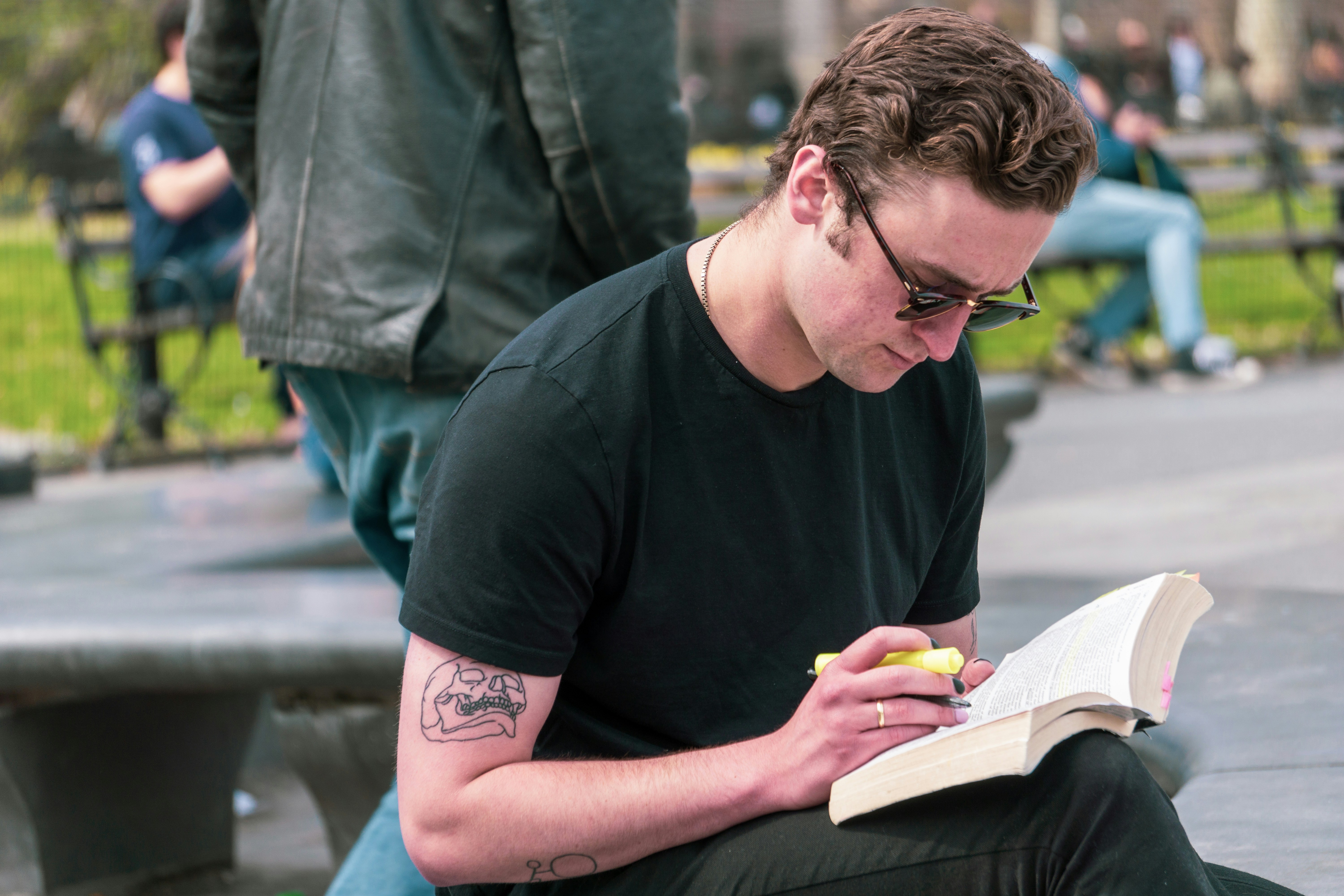a man sitting on a bench reading a book