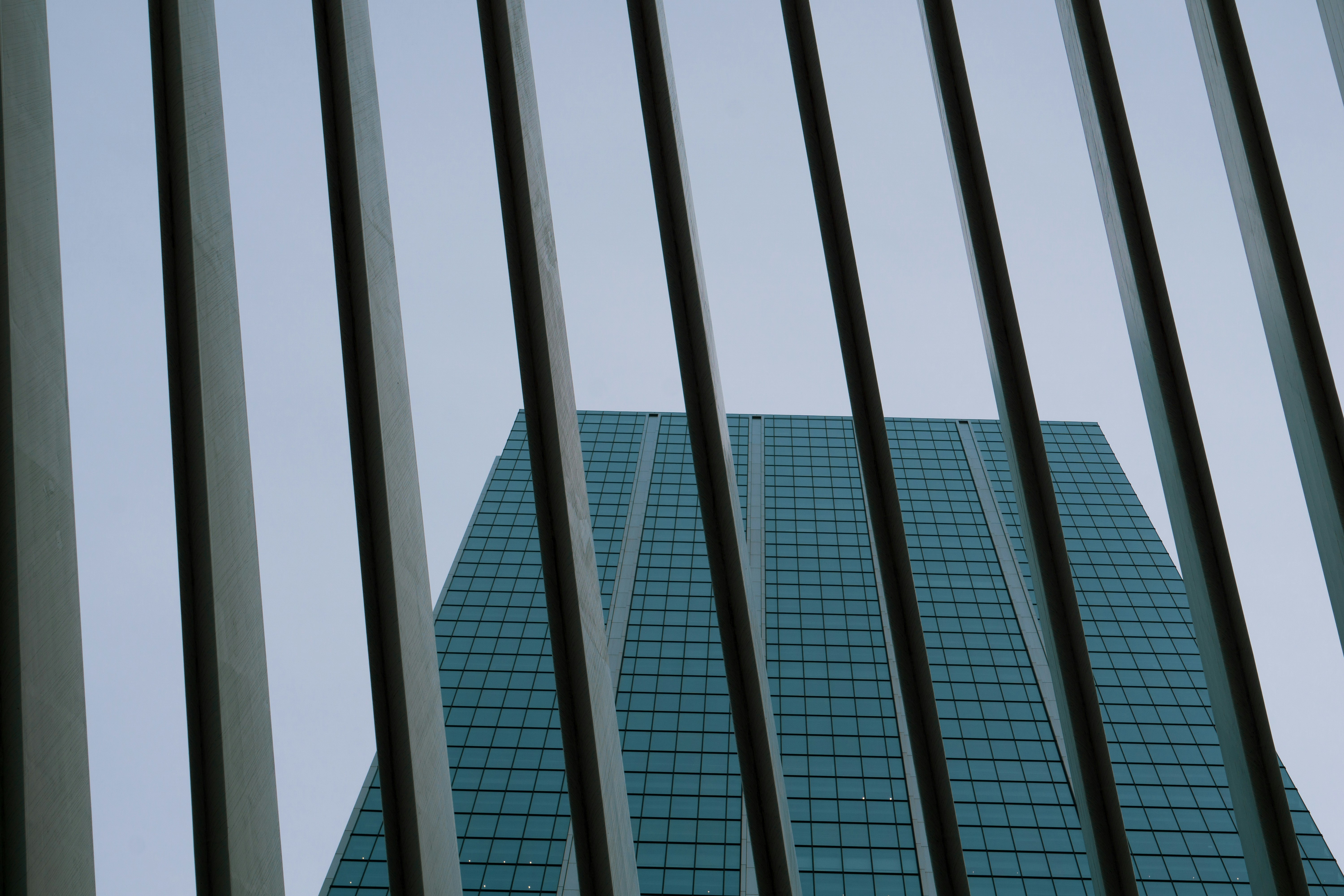 Framed Turquoise: A Glass Tower Through Vertical Slats