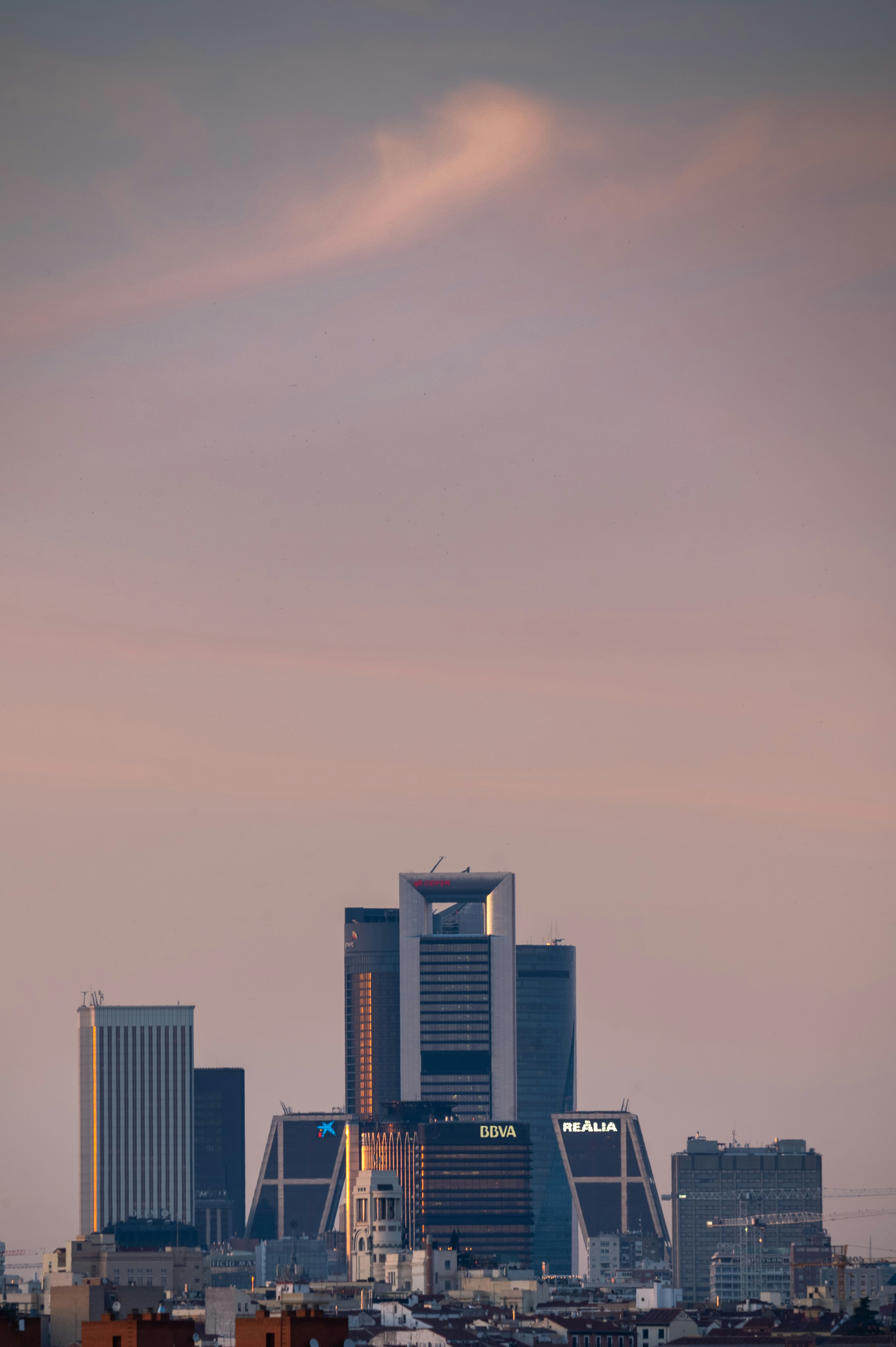 Modern skyscrapers silhouetted against a pastel sky, showcasing the architectural diversity of the urban landscape.