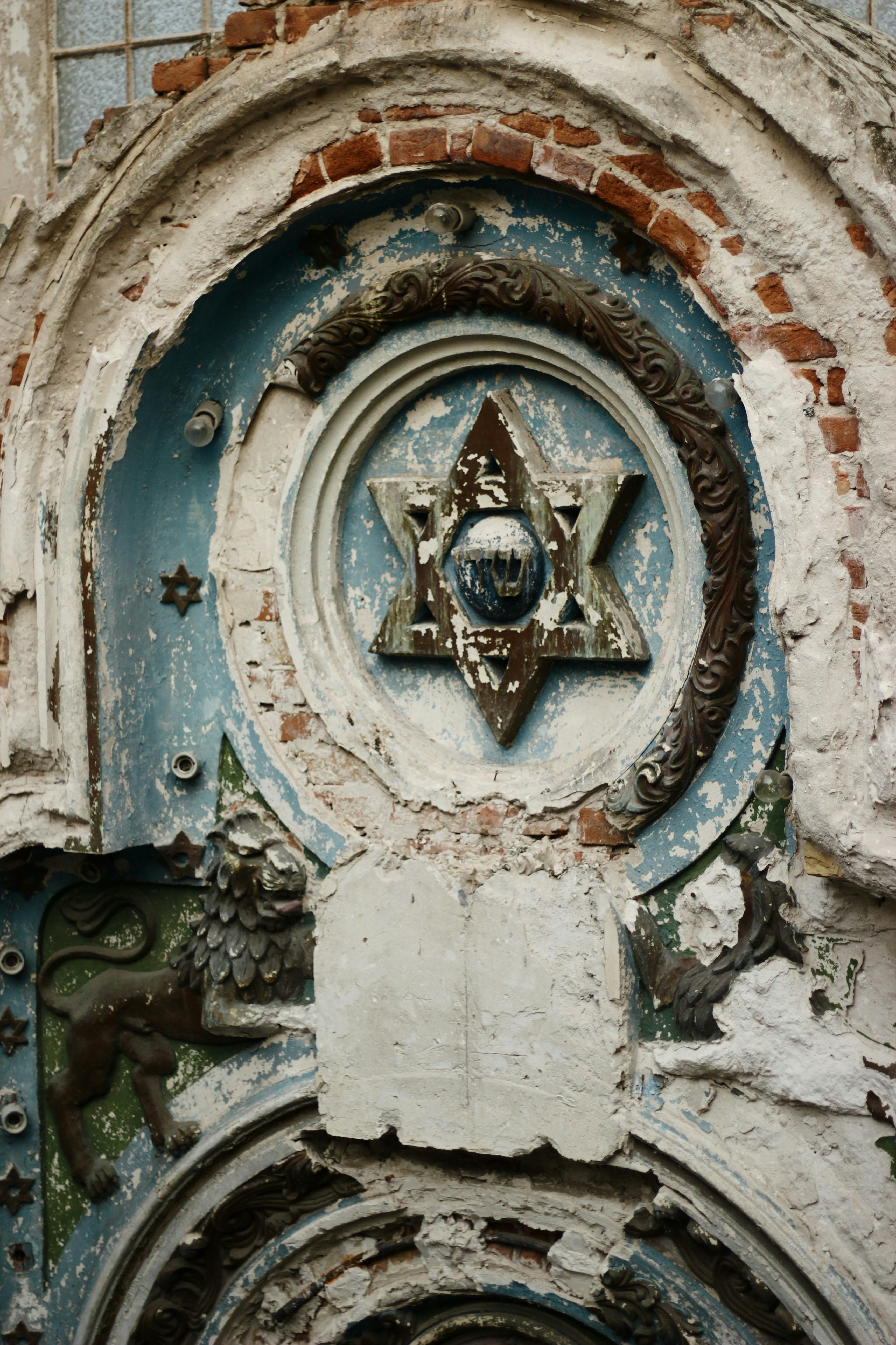 Star in Crumbling Blue: A Weathered Medallion on a Forgotten Façade