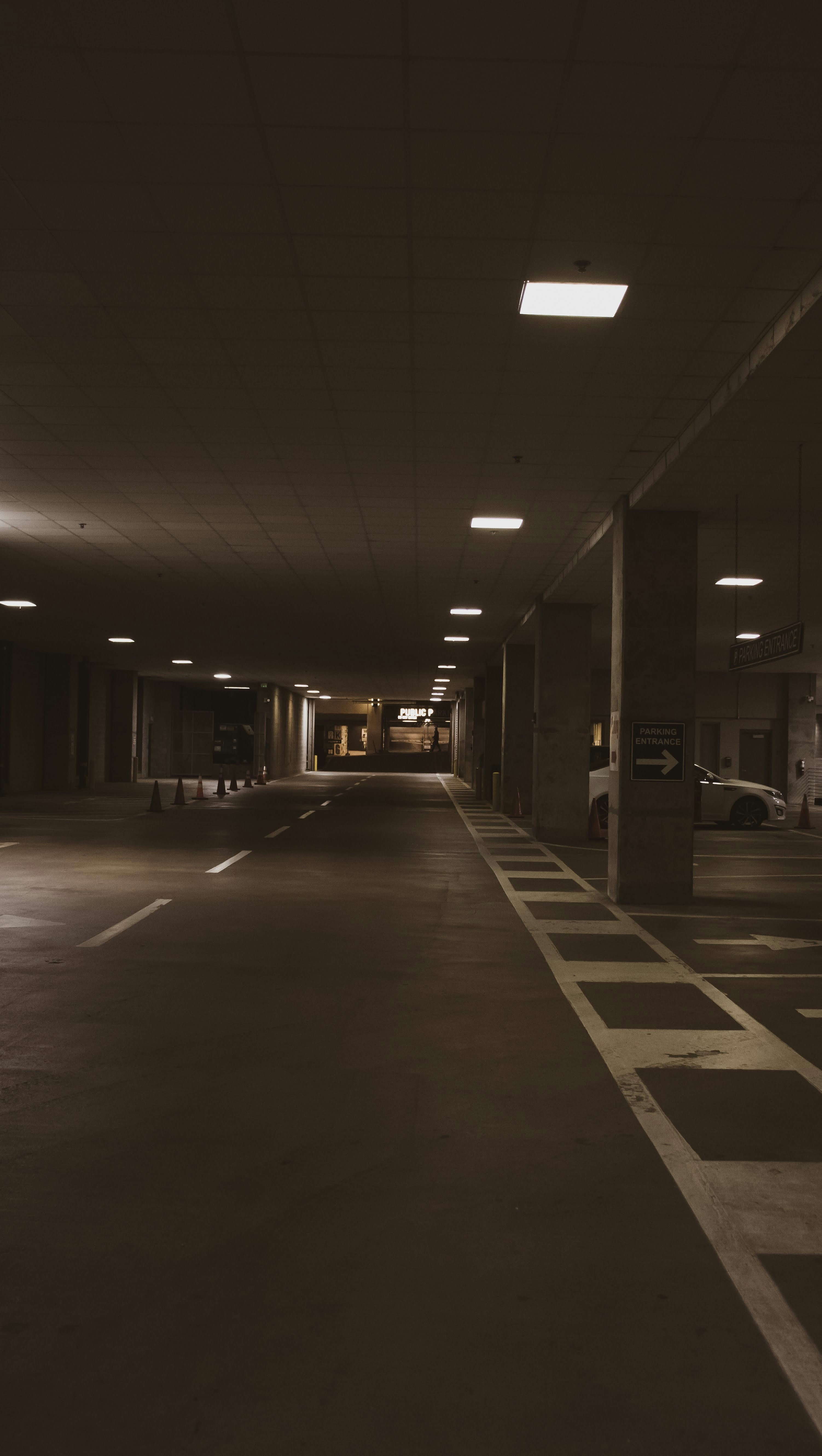 An empty parking garage at night with lights on photo – Free Parking ...