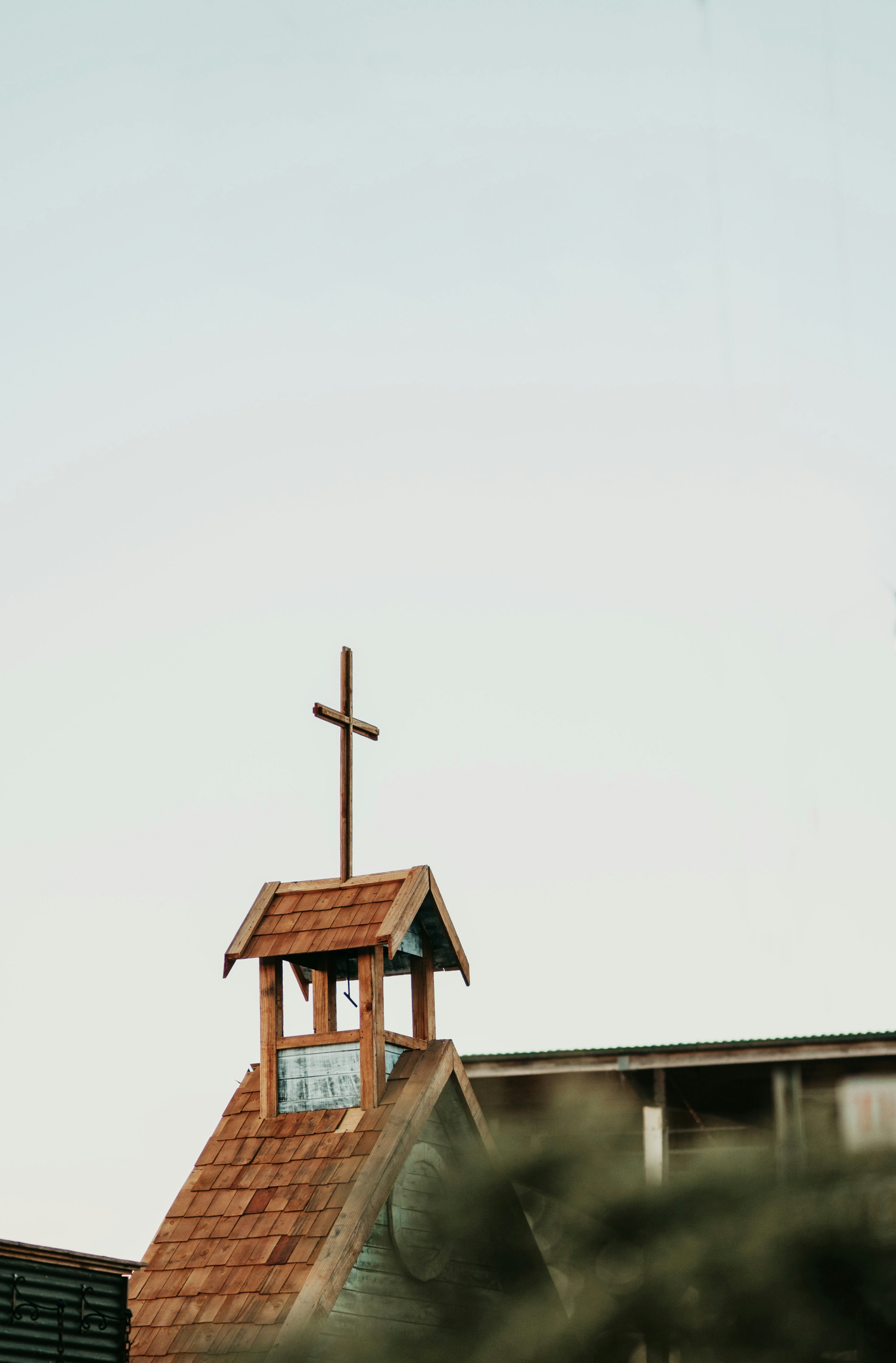 Cross on top of a building | a church steeple with a cross on top of it