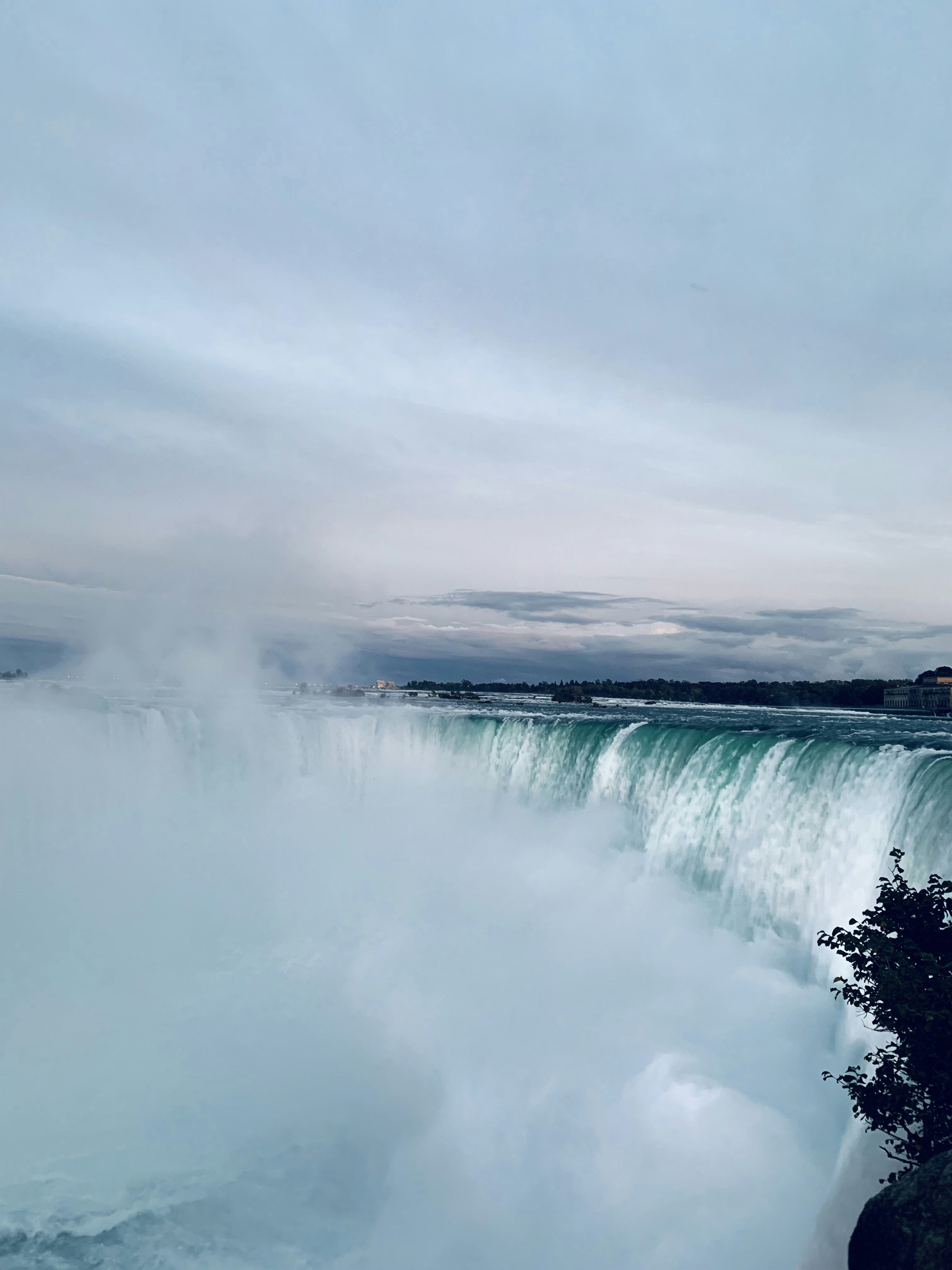 Emerald Veil Over the Cliff: A Wide Cascade Enveloped in Mist