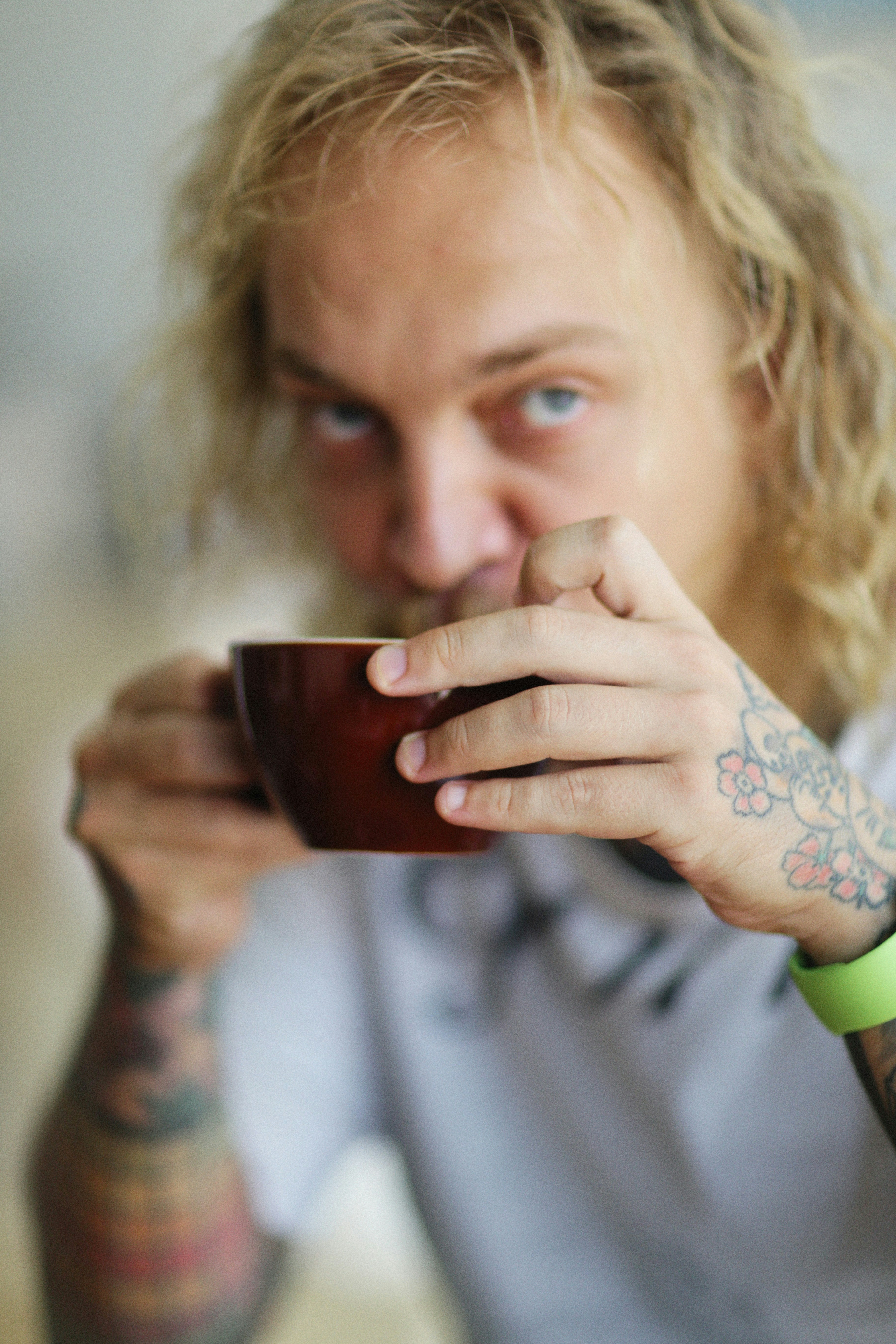 A man with a tattoo on his arm drinking from a cup photo – Free Person ...