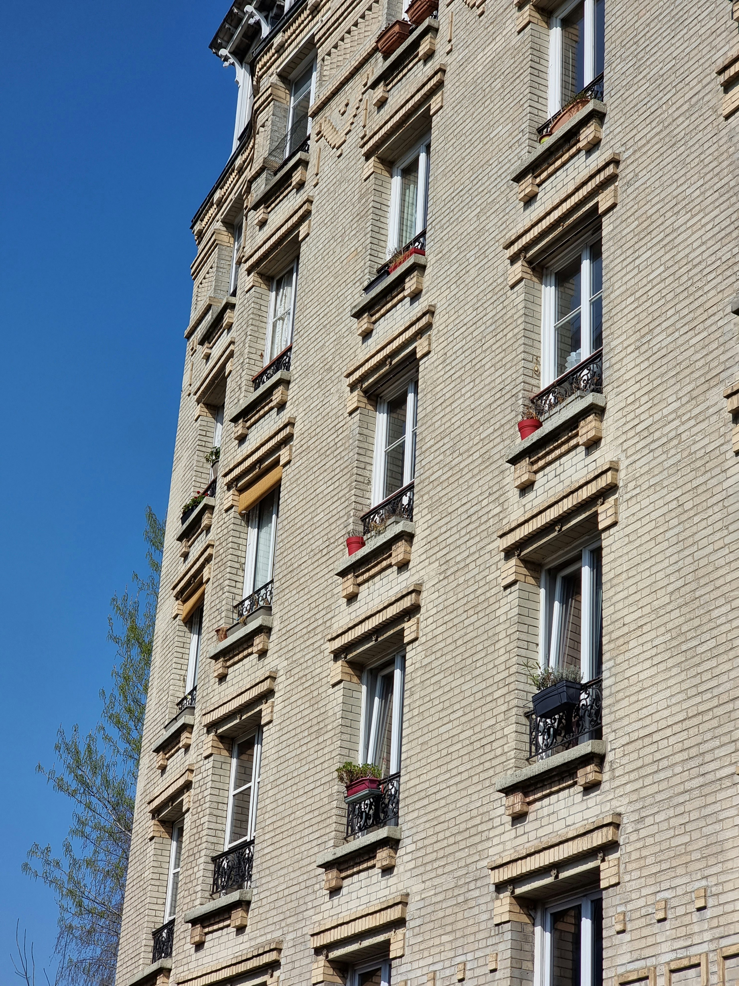 Brick Facade with Windows and Balconies Under a Clear Blue Sky