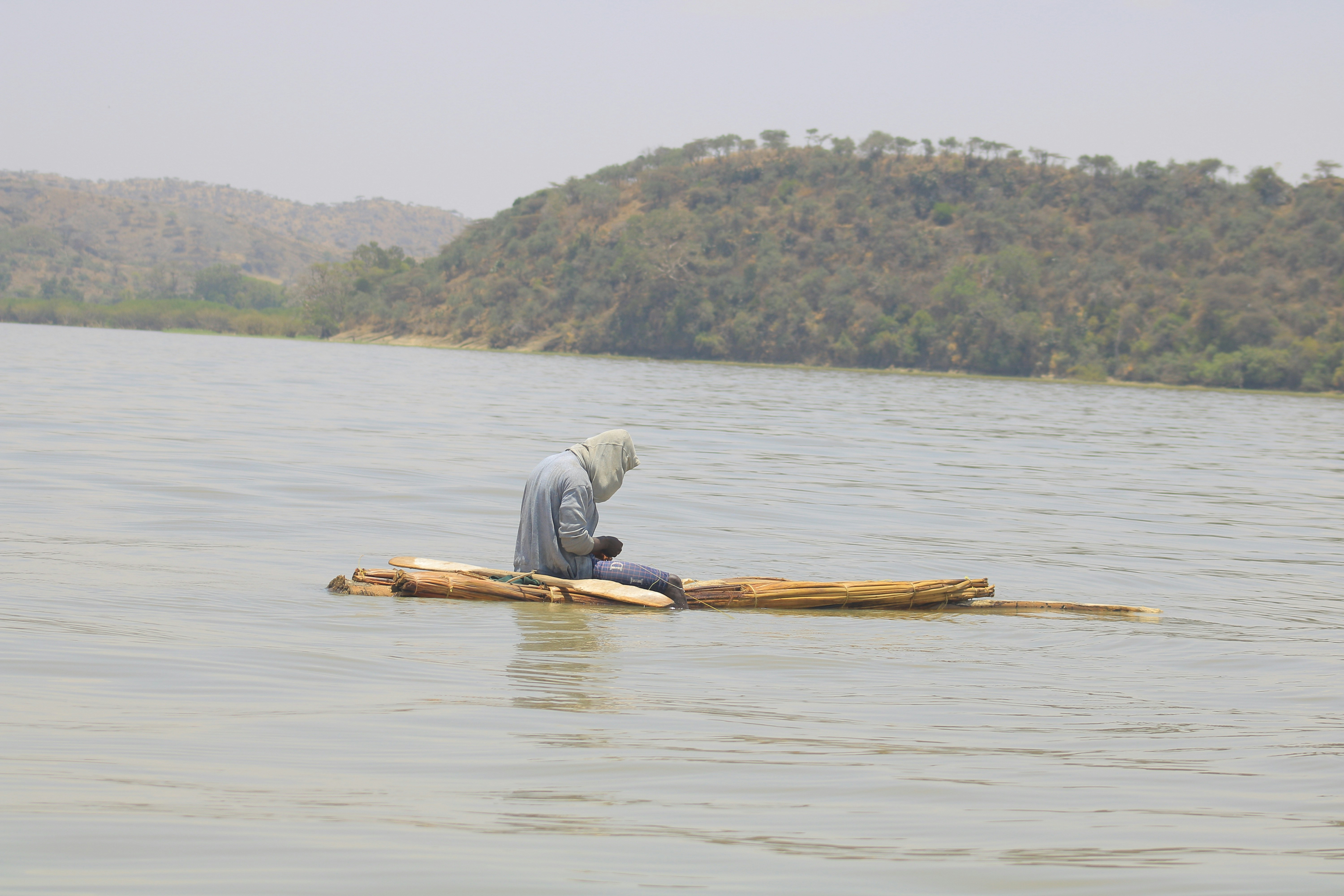Un homme est assis sur un radeau dans l’eau photo – Photo Bateau ...